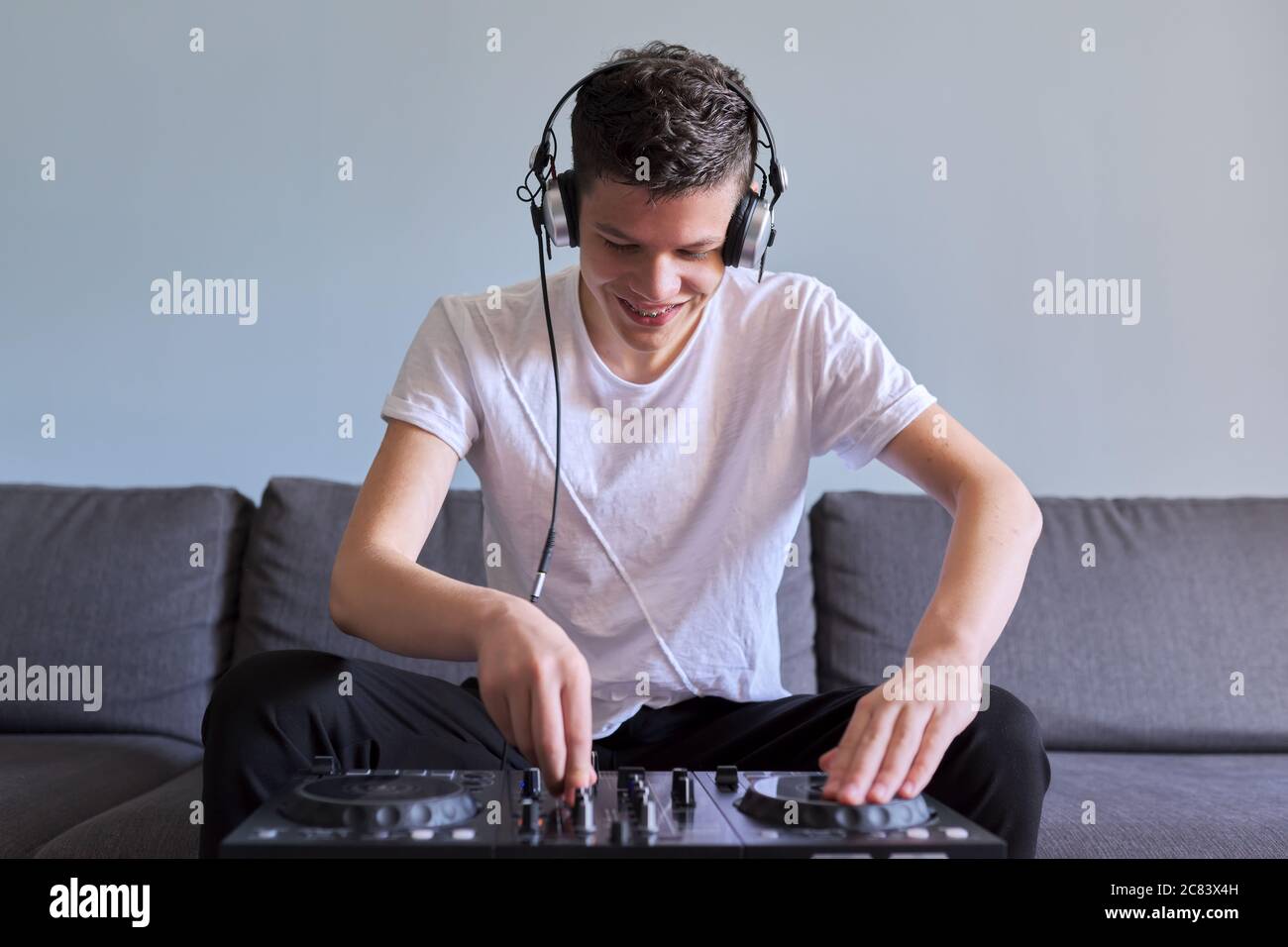 Creative teen boy in headphones with mixer equipment entertainment dj ...