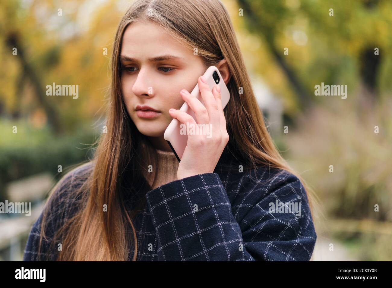 Portrait of sad girl talking on cellphone outdoor Stock Photo - Alamy