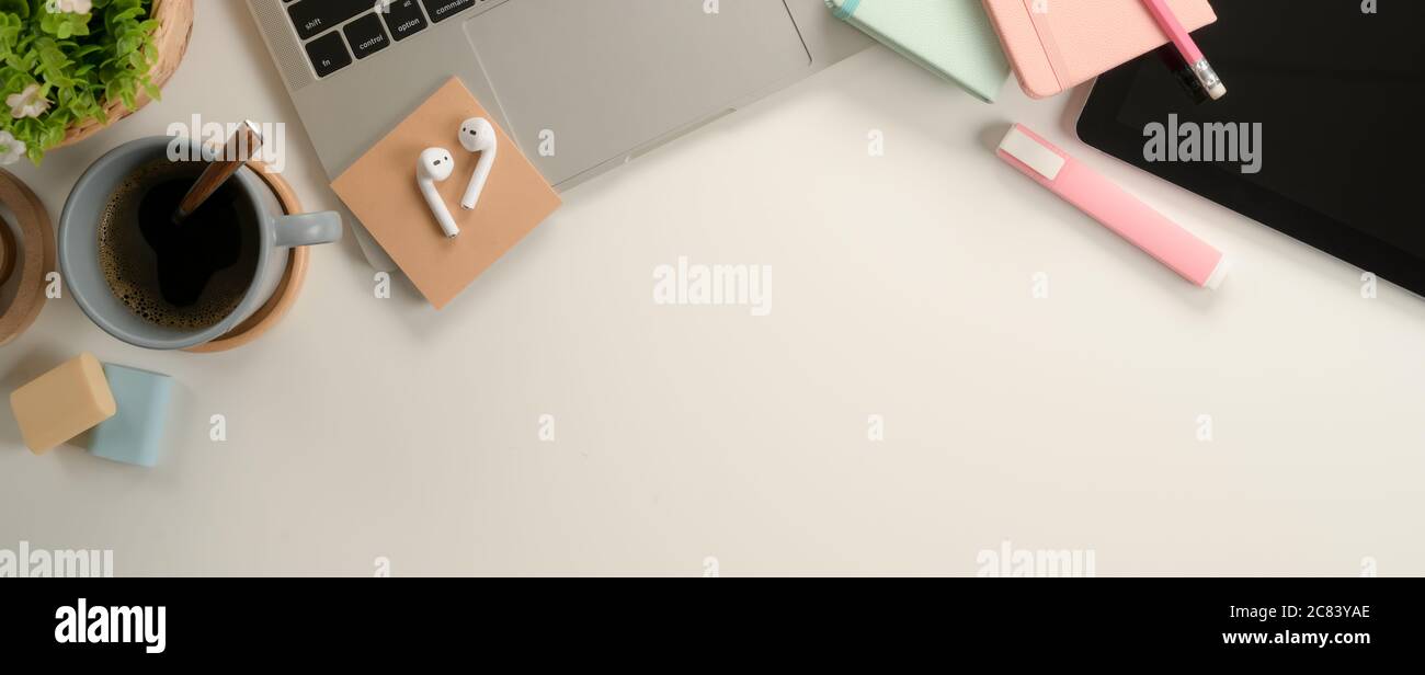 Top view of feminine study table with laptop, tablet, stationery ...