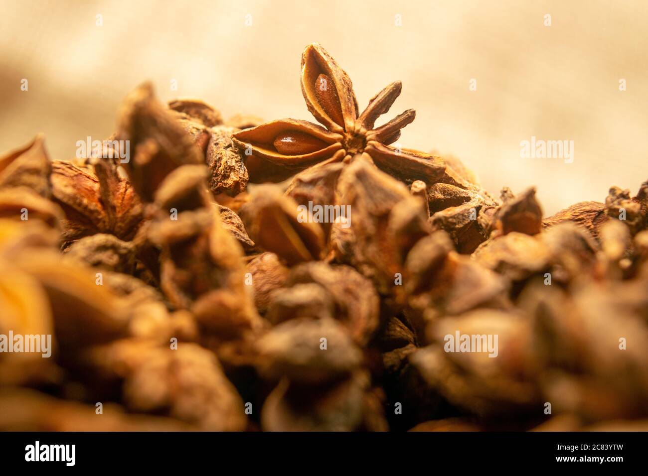 A pile of star anise on a background of burlap with a rough texture ...