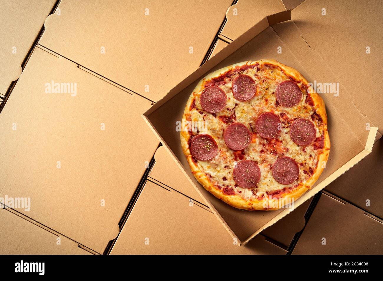 Traditional Italian salami pizza in an open brown cardboard takeaway ...