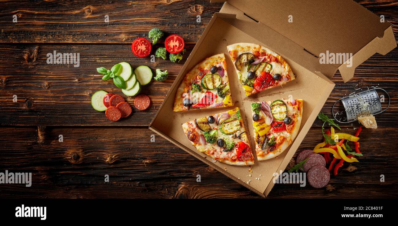 Takeaway Italian pizza in a box with fresh diced prepared vegetable ...