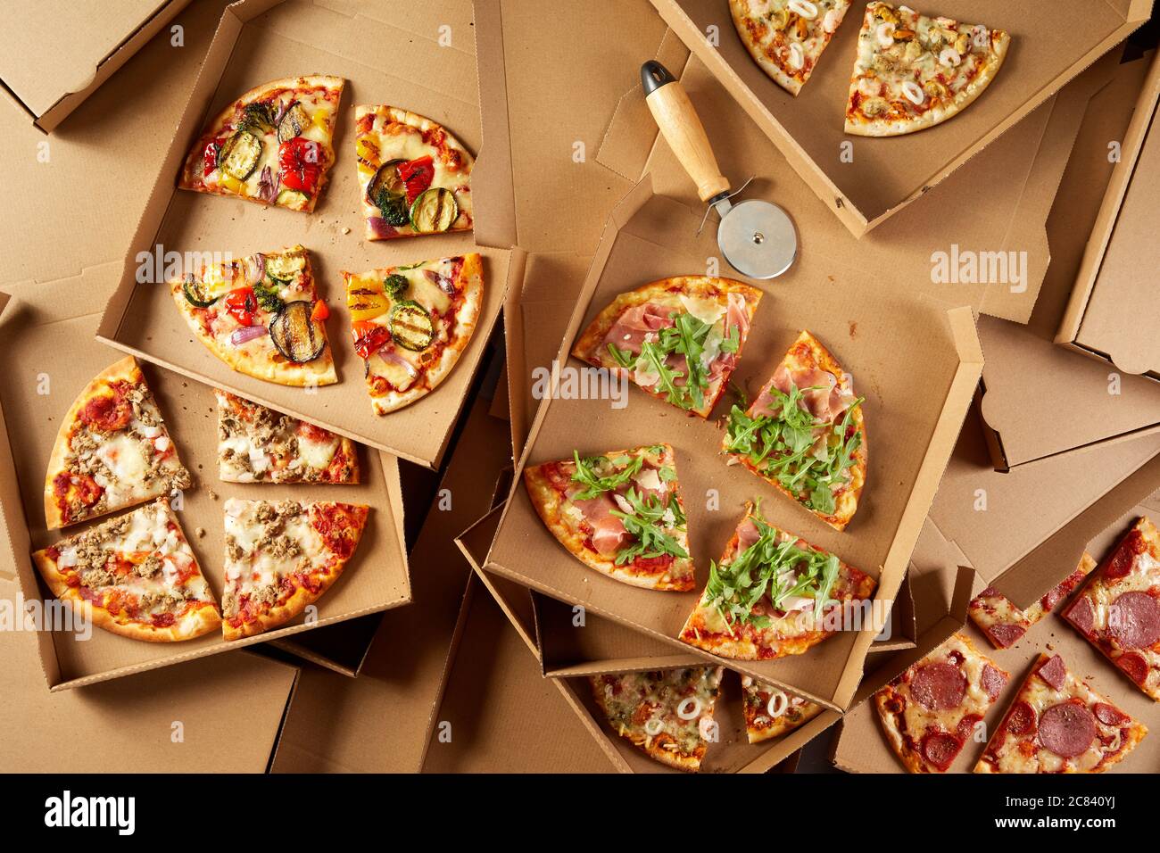 Large assortment of toppings on Italian pizzas in individual cardboard ...