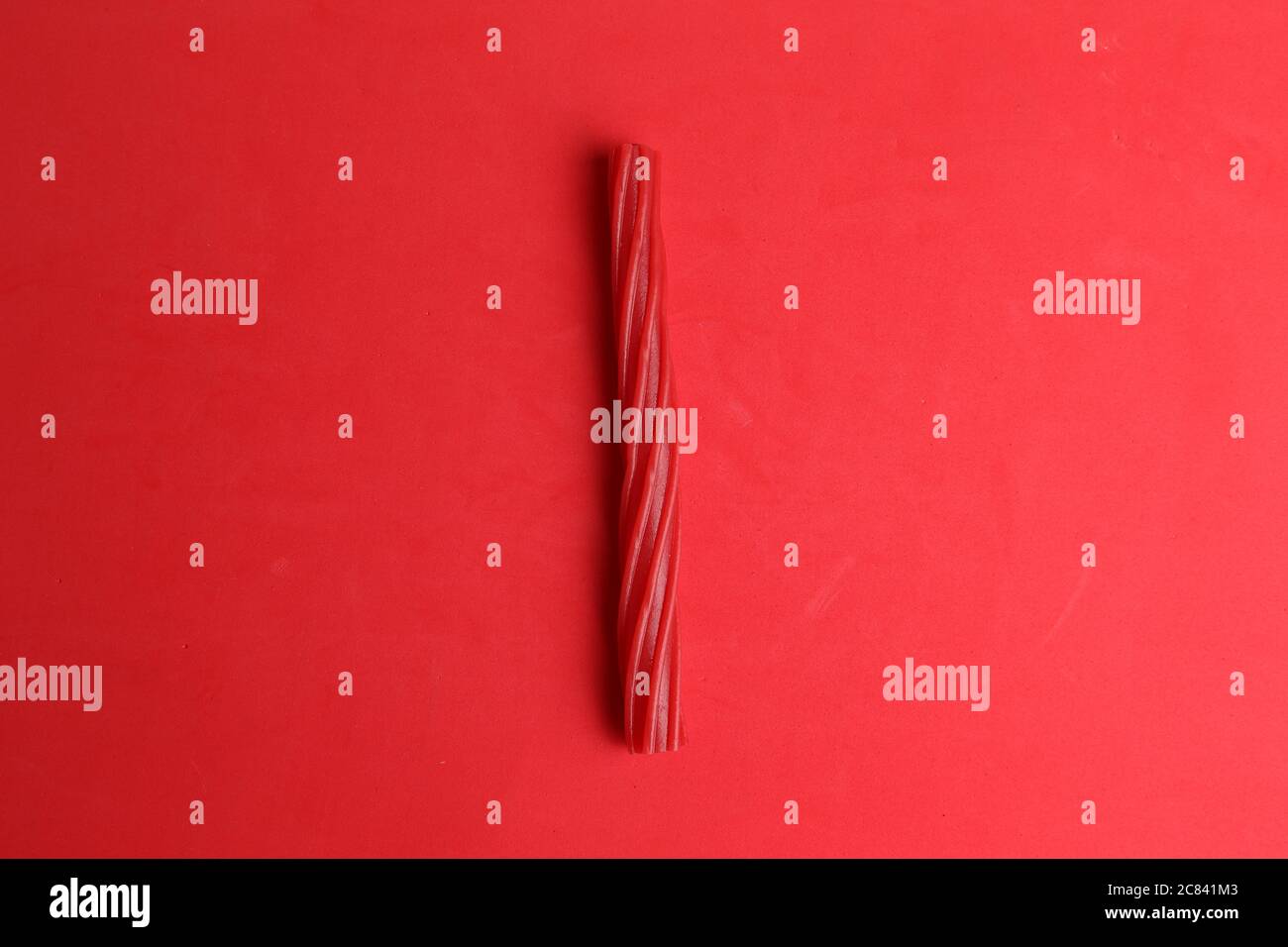 Red tasty candy stick on a red background Stock Photo - Alamy