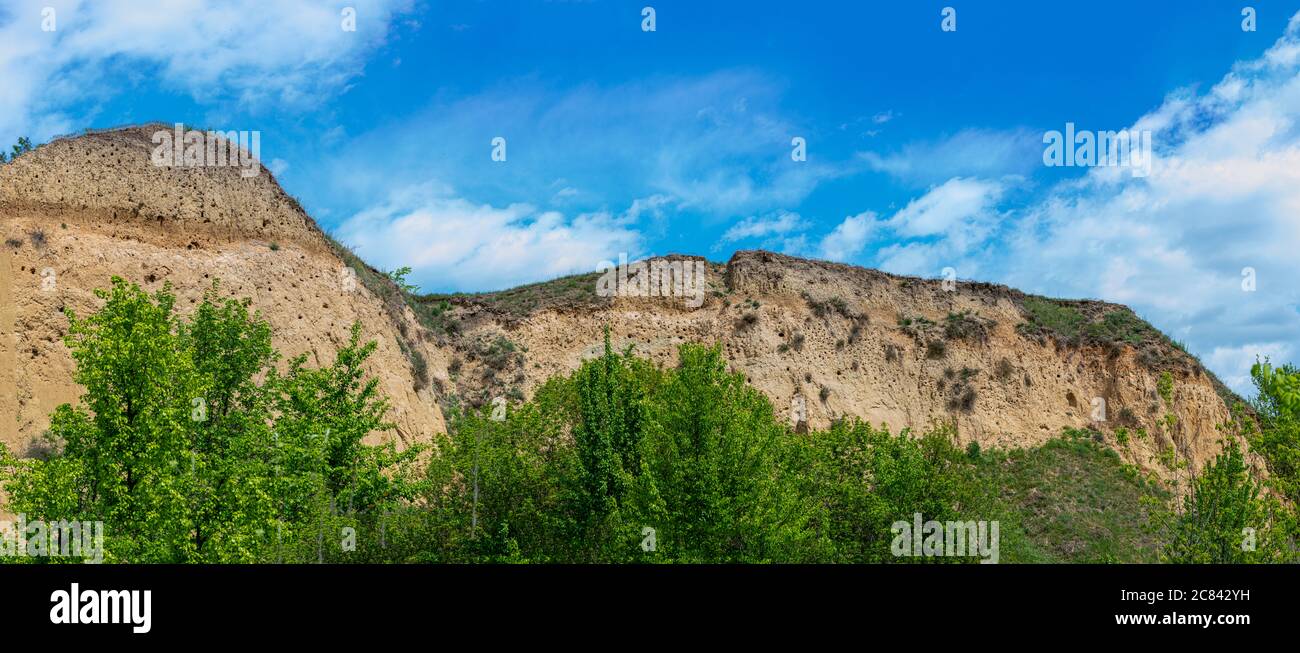 High clay cliff at bright sunny day on blue sky background Stock Photo ...