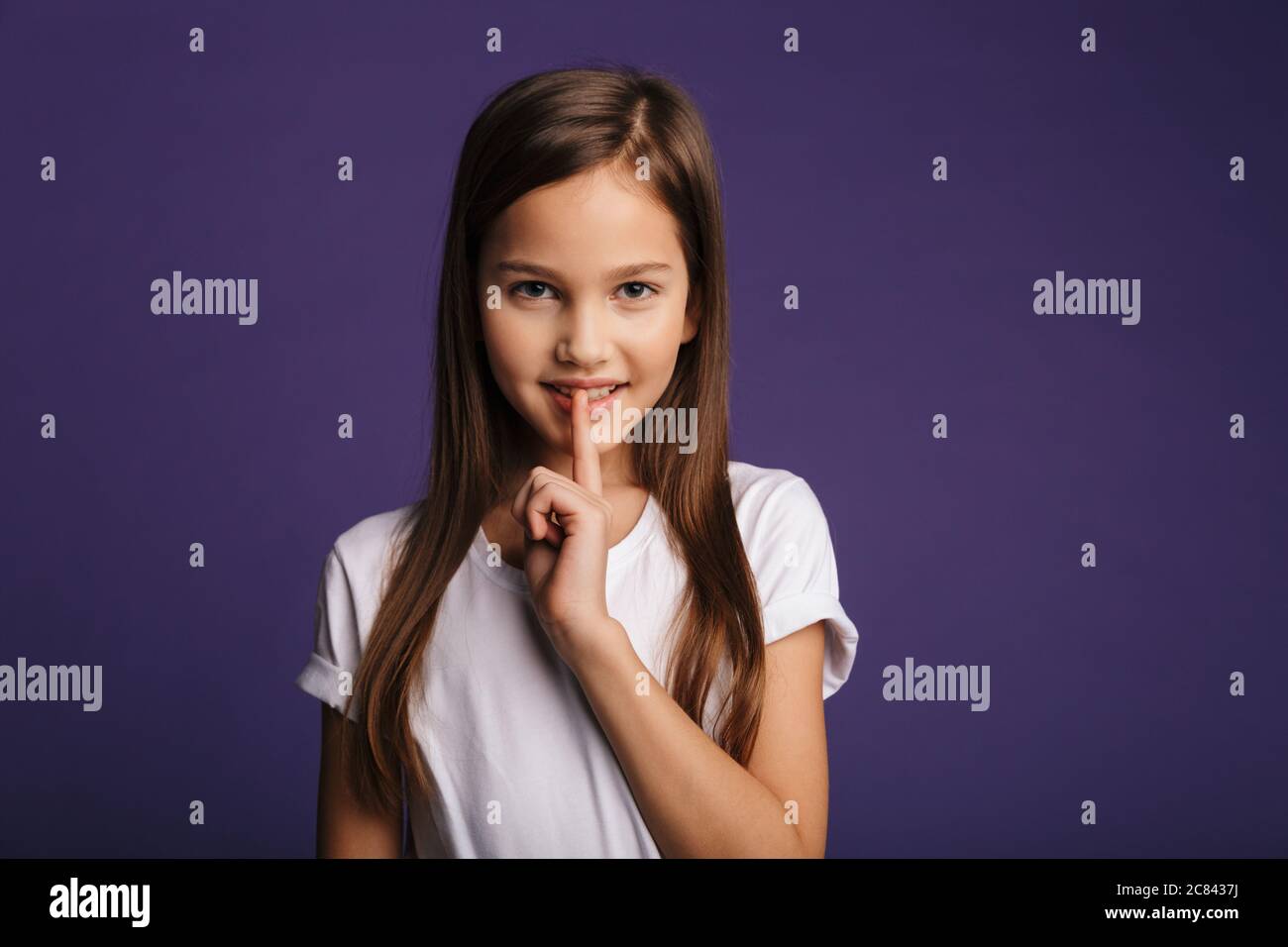 Photo of happy beautiful girl smiling and making silence gesture ...