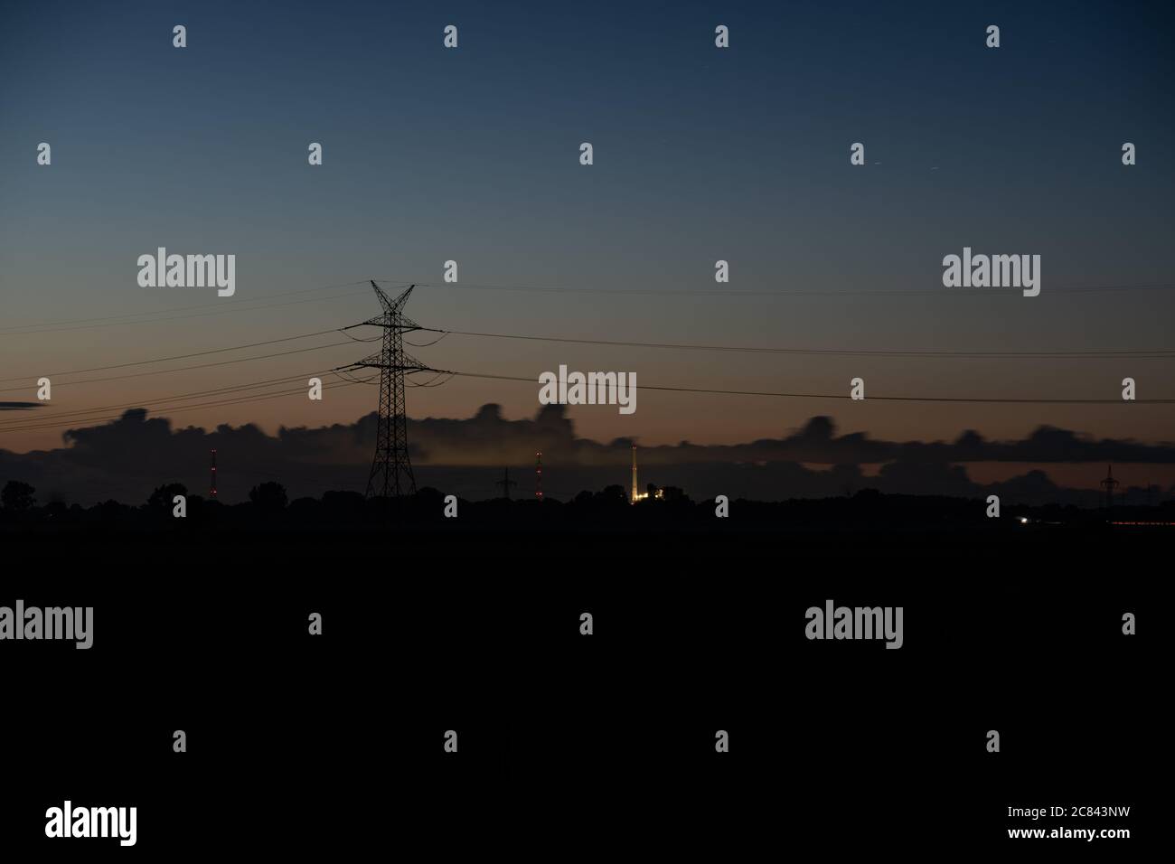 glowing wind turbines with their red lights on the horizon in the dark ...