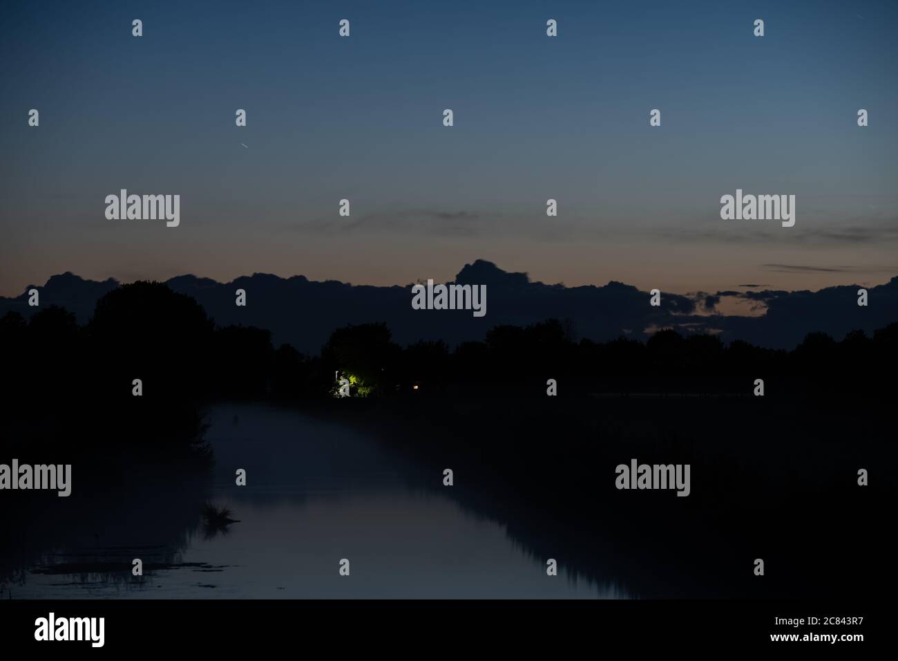 a river glows at night with the horizon along with dark landscape Stock ...