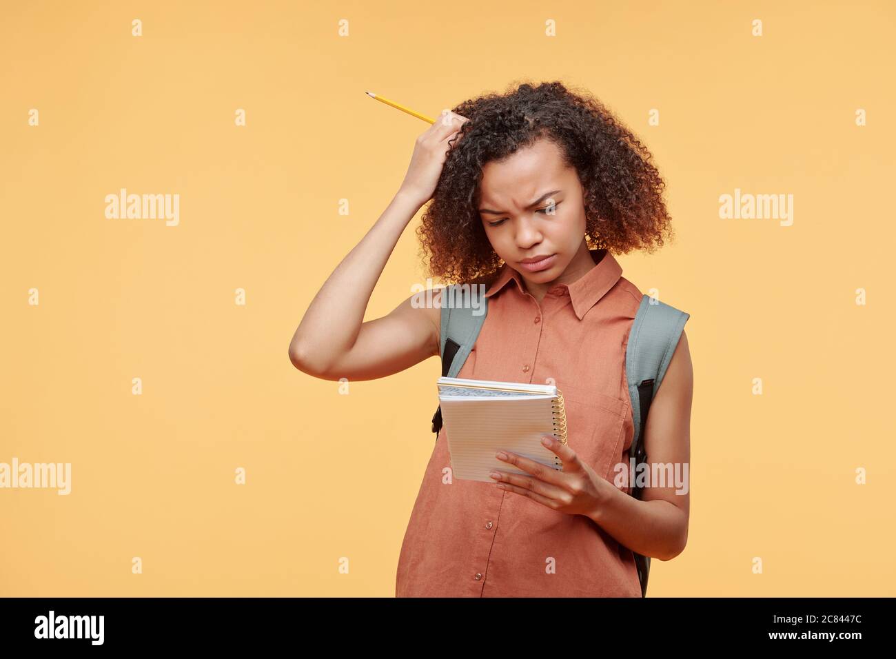 Thoughtful frowning black student girl with curly hair focused on ...