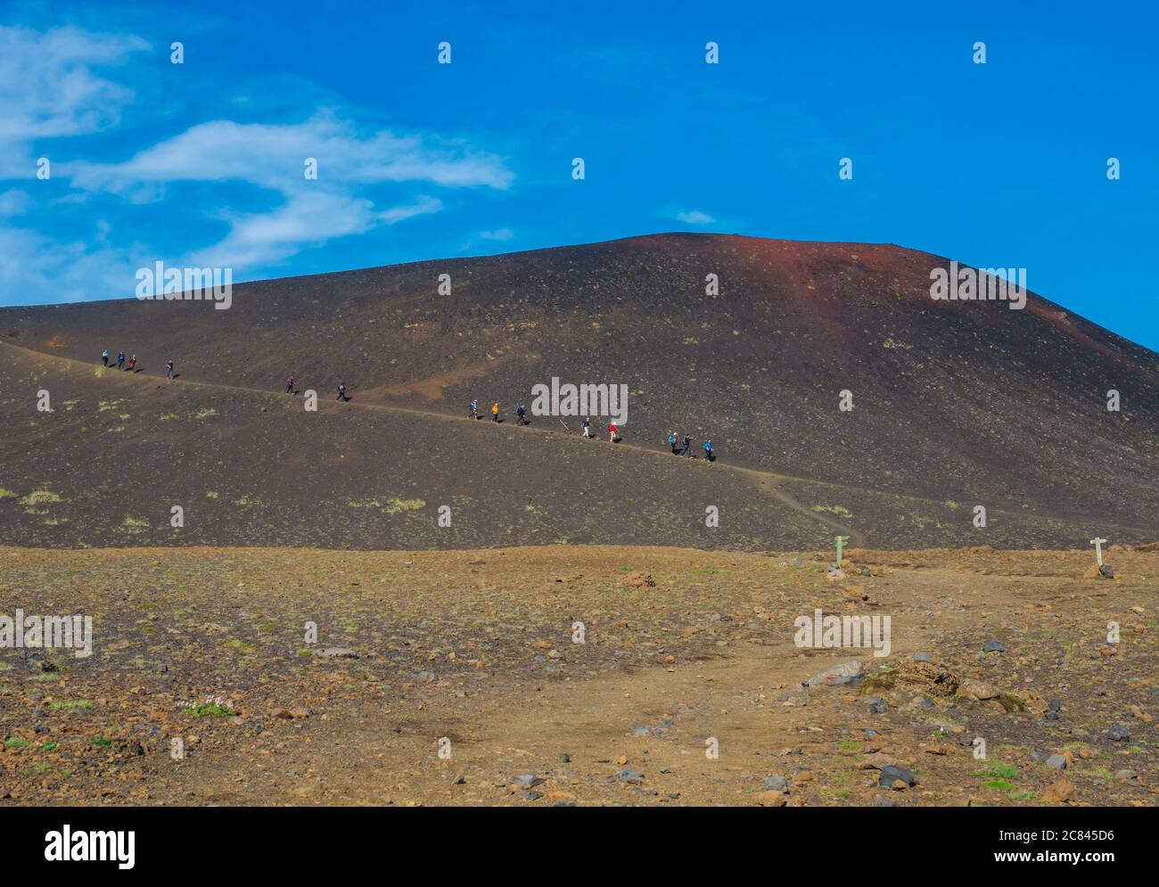 Icelandic lava desert landscape with group of hikers walking down from ...