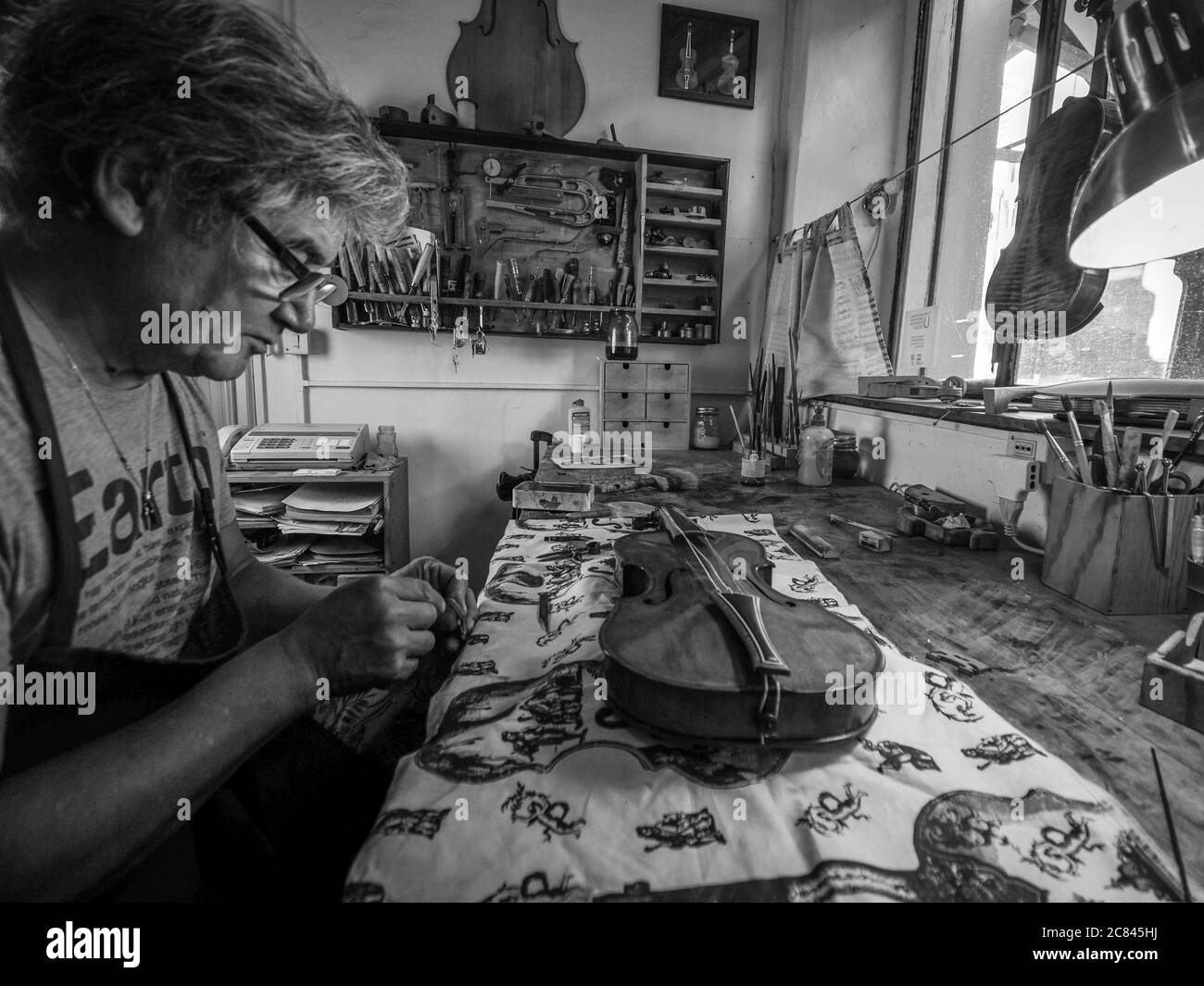 Luthier violin maker Carlos Roberts working in his workshop in Cremona ...