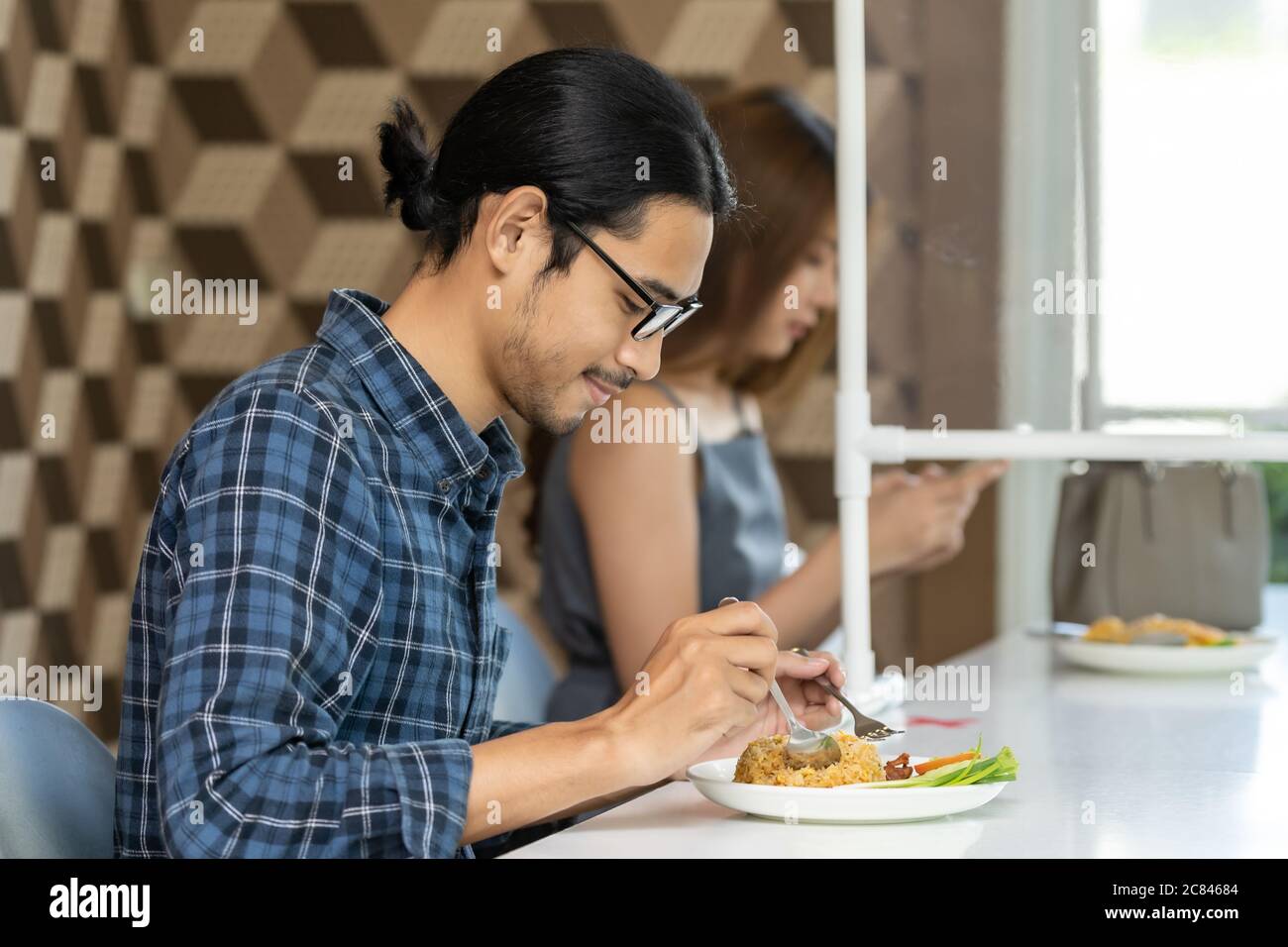 Asian customer eating out at new normal social distance restaurant with ...