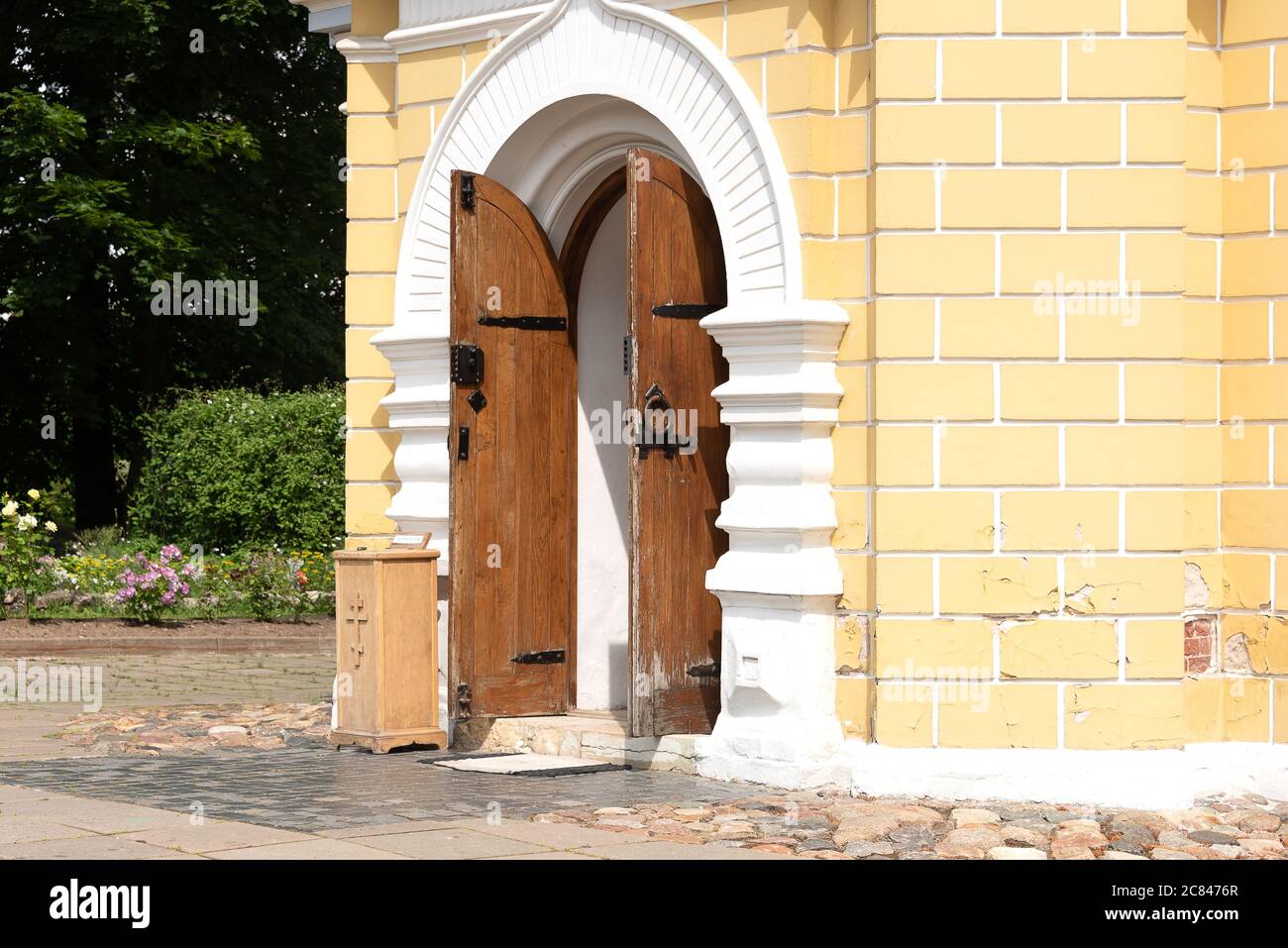 Open wooden doors of the old temple. Arch entrance, oak wood doors ...
