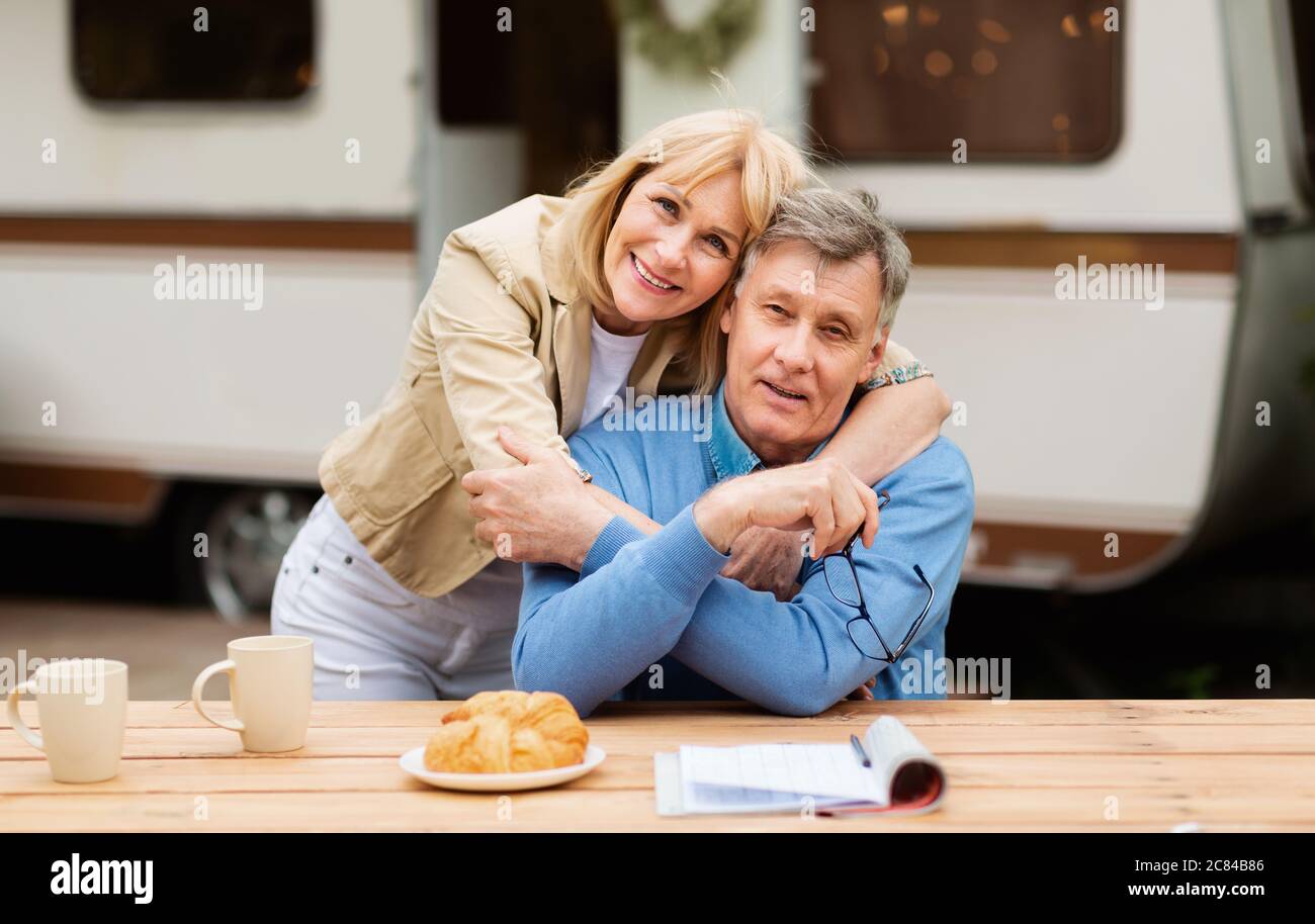 Beautiful mature woman hugging her beloved husband near camper van ...