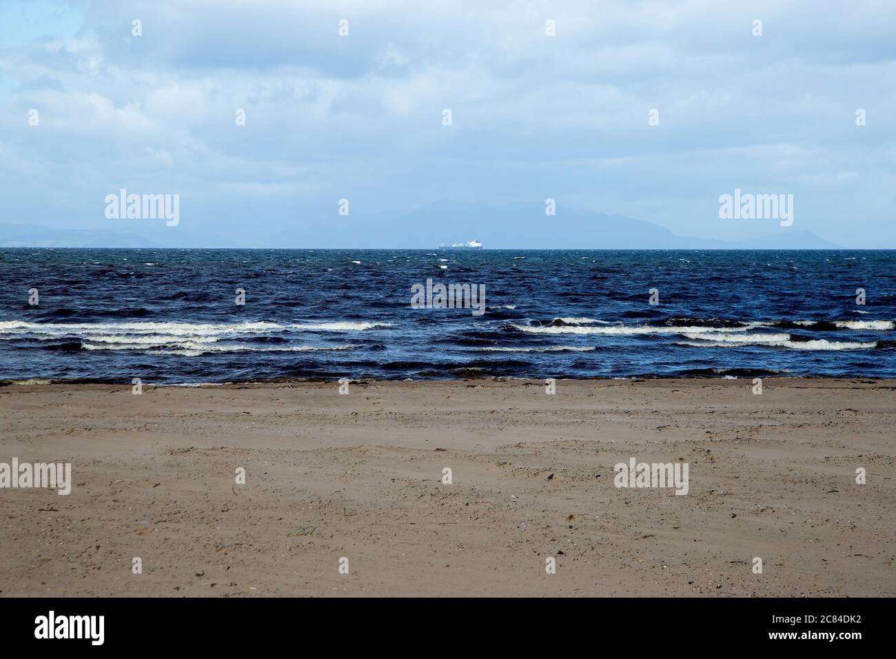 Distant cargo ship viewed from a deserted coastal beach Stock Photo - Alamy