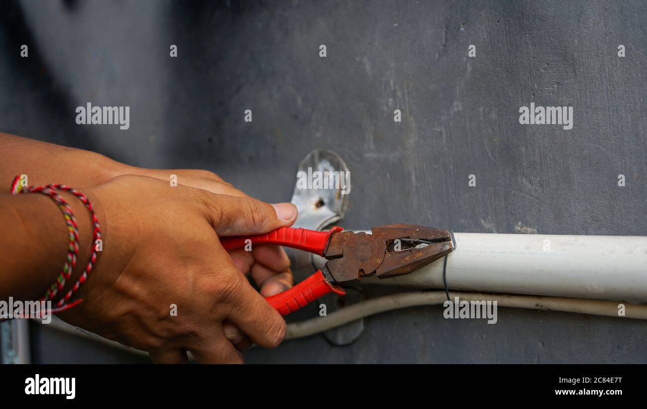 Close up hand holding pliers Stock Photo - Alamy