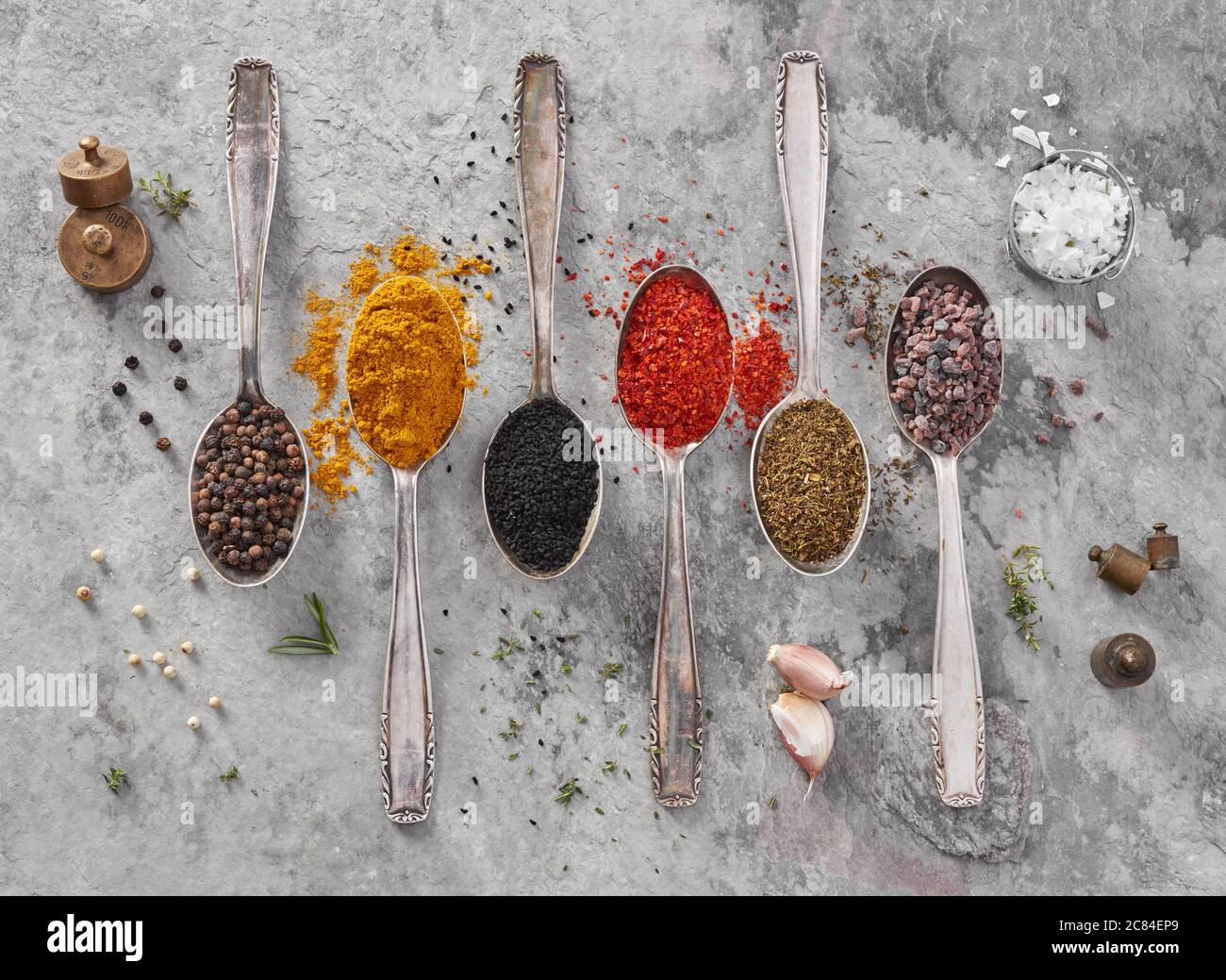 Spoons with spices on gray background Stock Photo - Alamy
