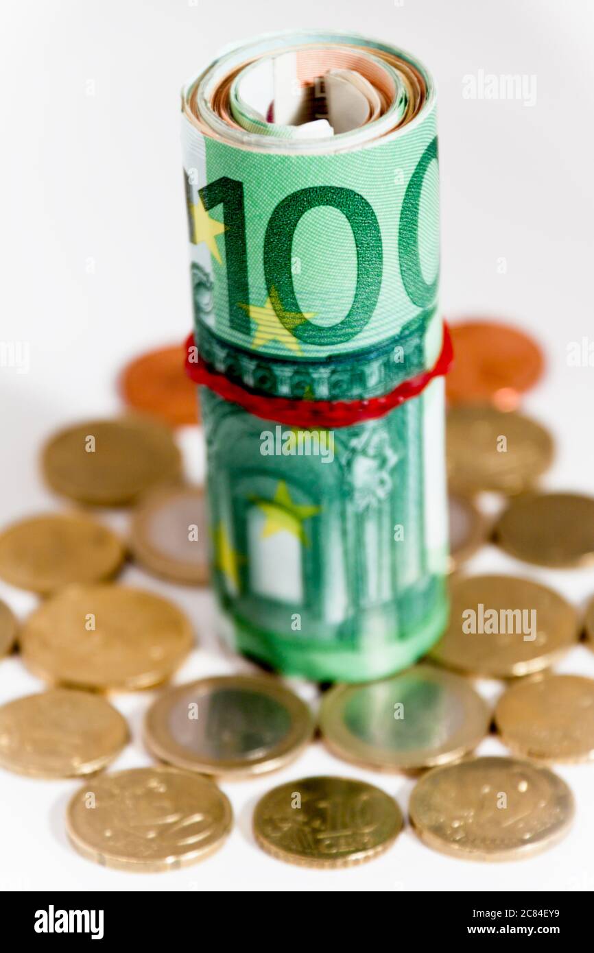 banknotes rolled up in a tube and scattered change next to them Stock ...