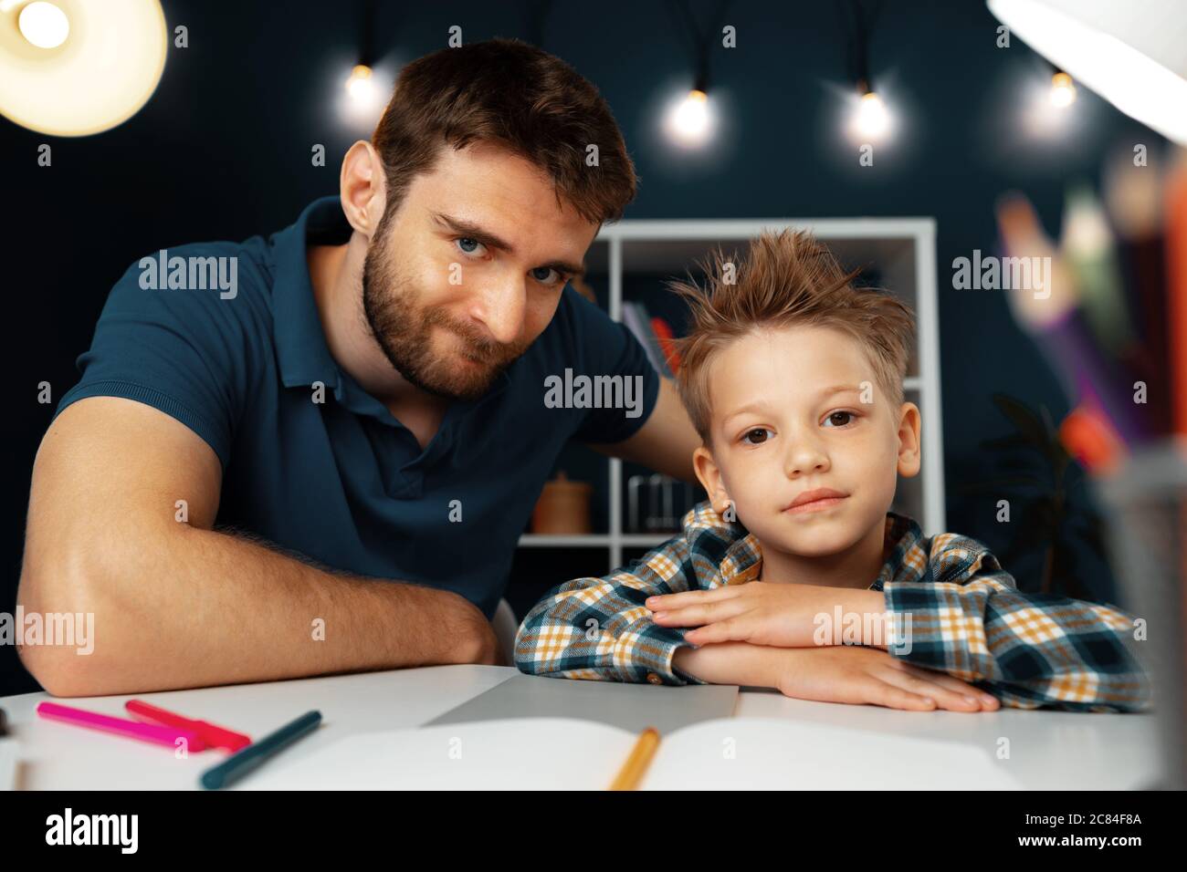 Dad and son doing school homework together Stock Photo - Alamy