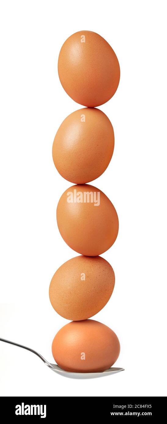Eggs stack in balance white background Stock Photo - Alamy