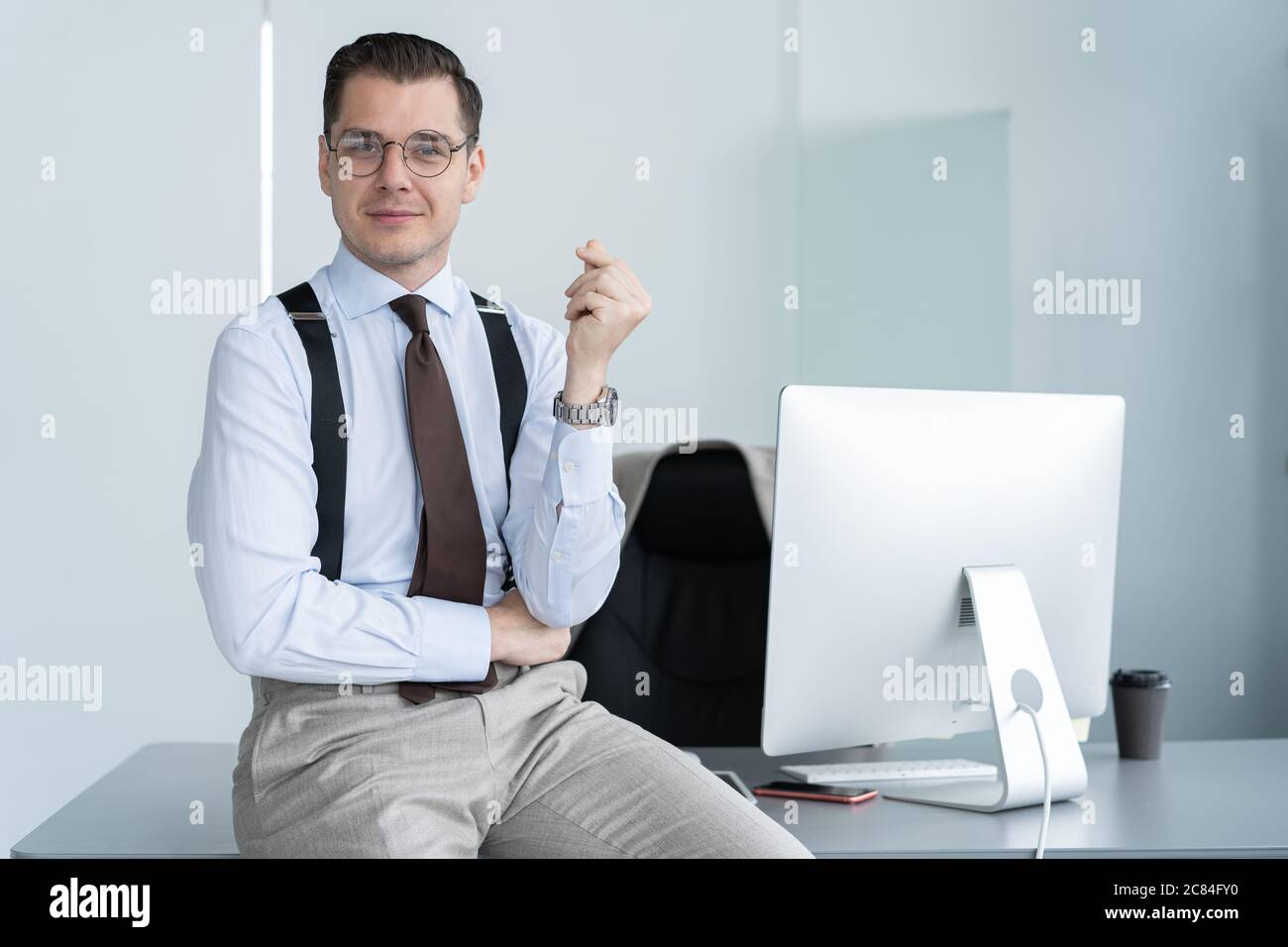 Portrait of a confident young businessman standing alone in a large ...