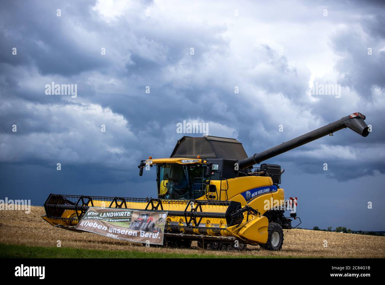 Leezen, Germany. 21st July, 2020. A combine harvester with a banner of ...