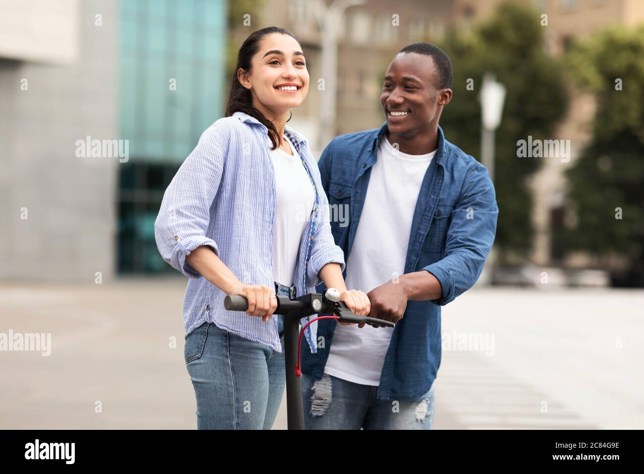 Couple having pleasant ride on electric kick scooter Stock Photo - Alamy