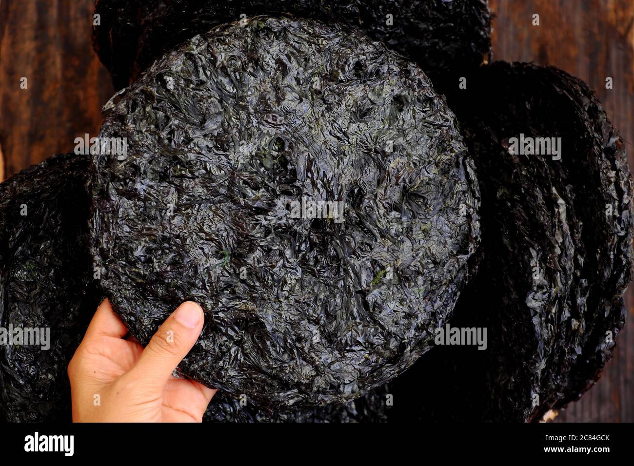 Top view group circle sheet dried black seaweed in basket, woman hand ...
