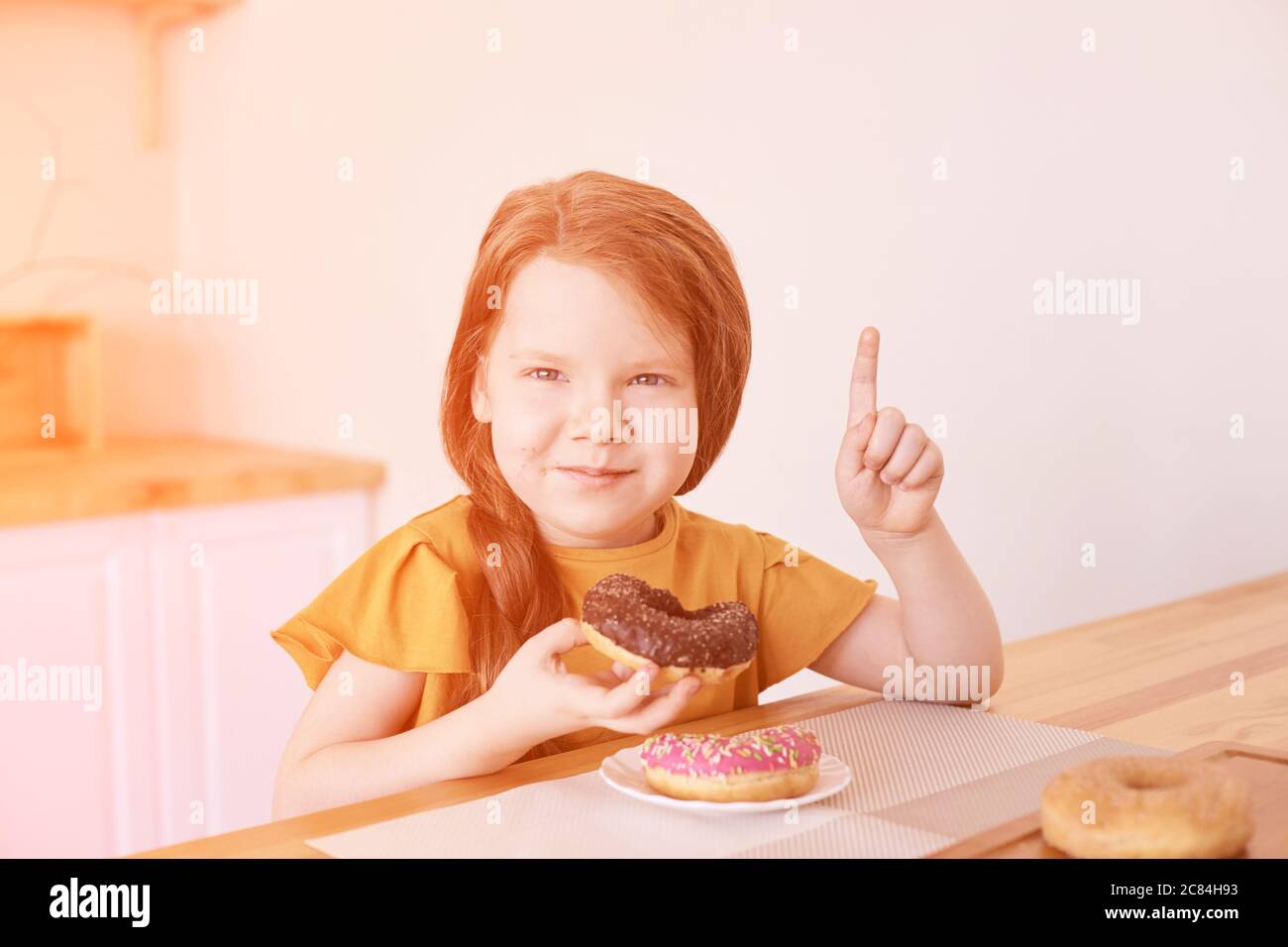 Little girl eating round doughnut. Sweet desert. Unhealthy food ...