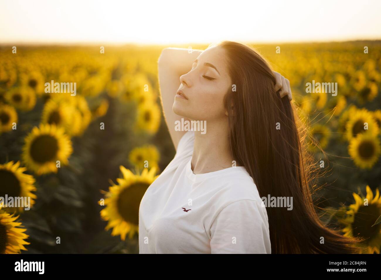 Shallow focus shot of pretty European female in a sunflower field at ...
