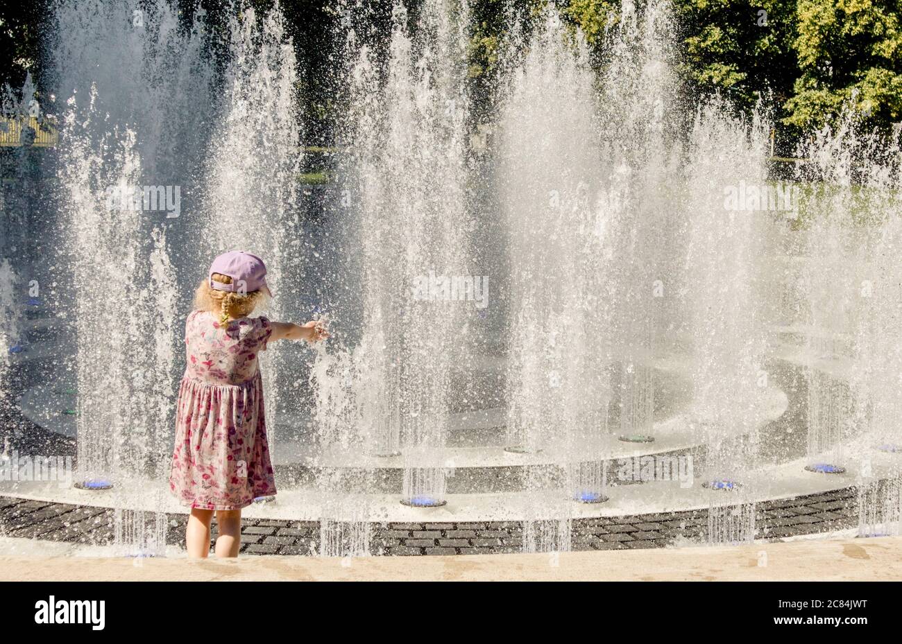 Children playing in water splashing fountain in public park, having fun ...
