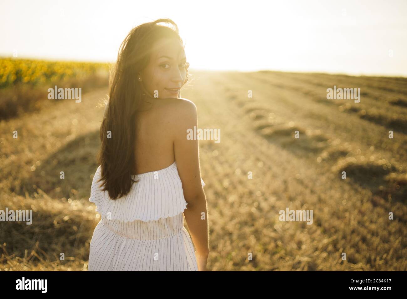 Shallow focus shot of pretty Caucasian female in a sunflower field at ...