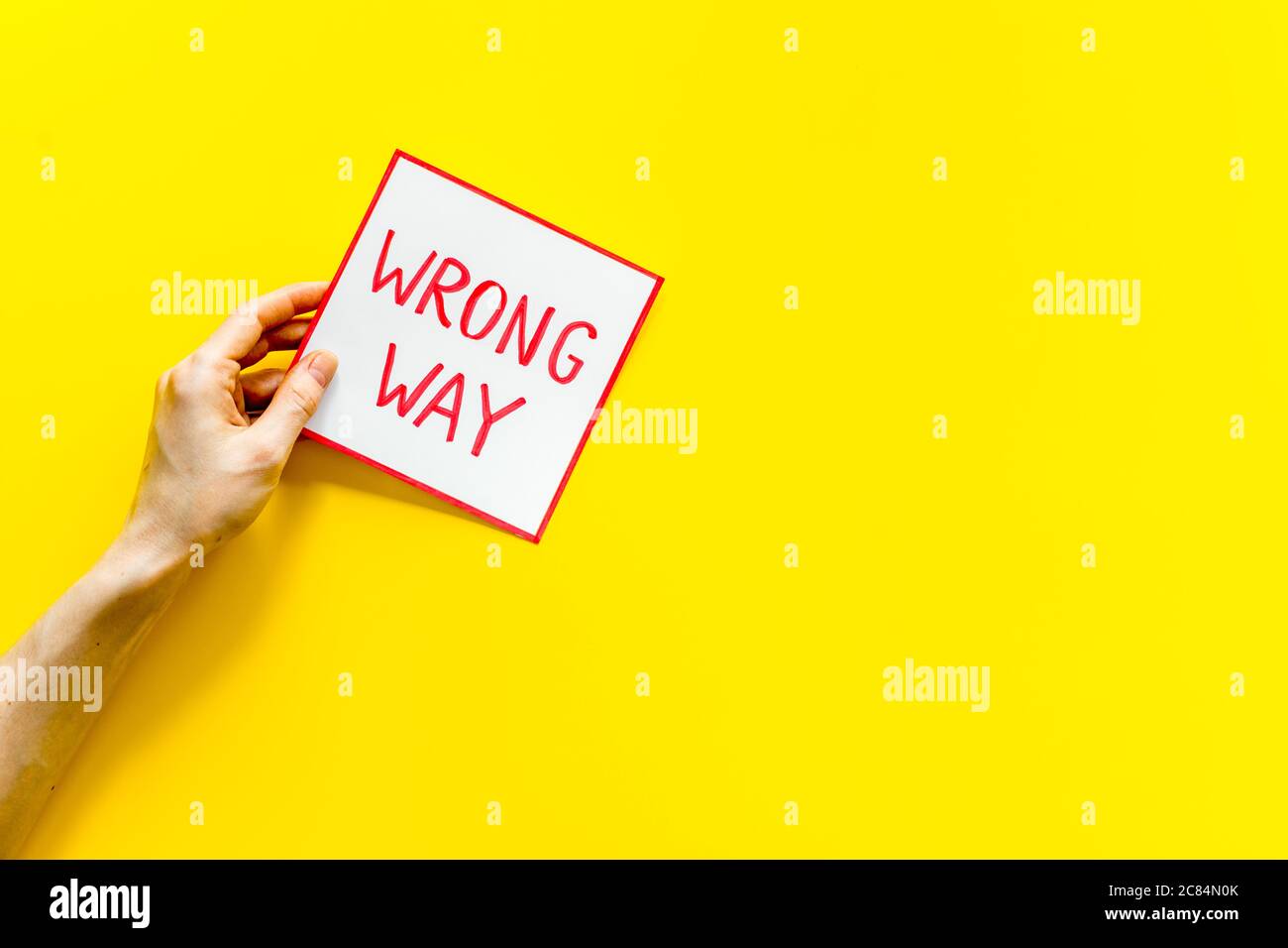 Business failure. Wrong way icon in hands on office desk top-down copy ...