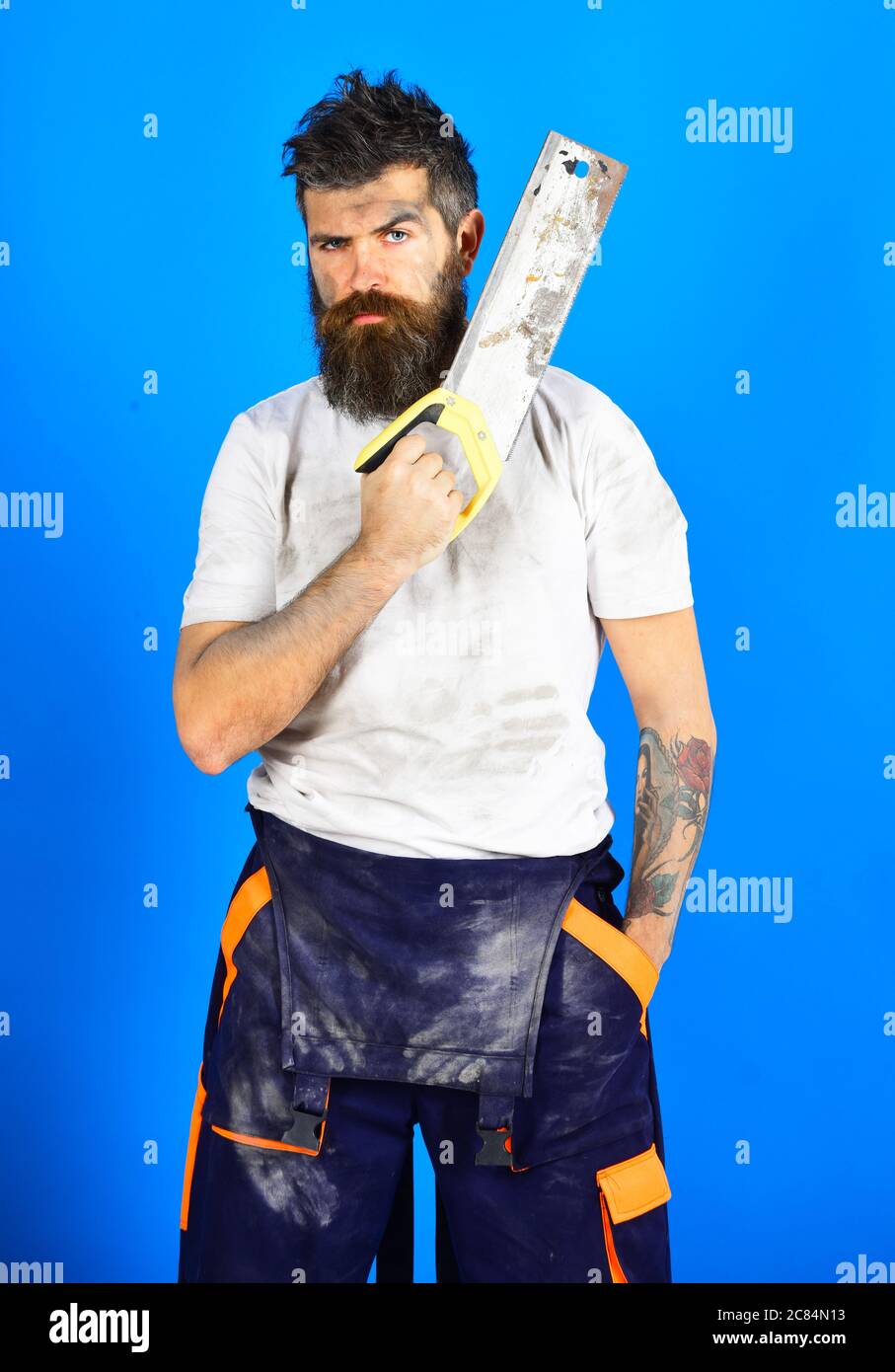 Builder, worker, carpenter, handyman holds saw or hacksaw, blue ...