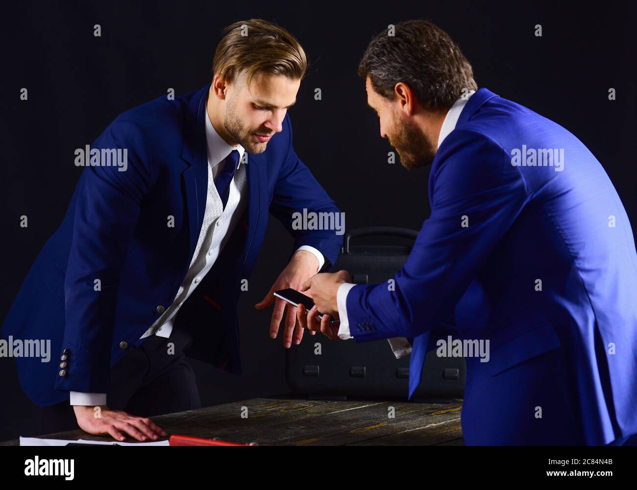 Men in suit or businessmen with concentrated expression with smartphone ...