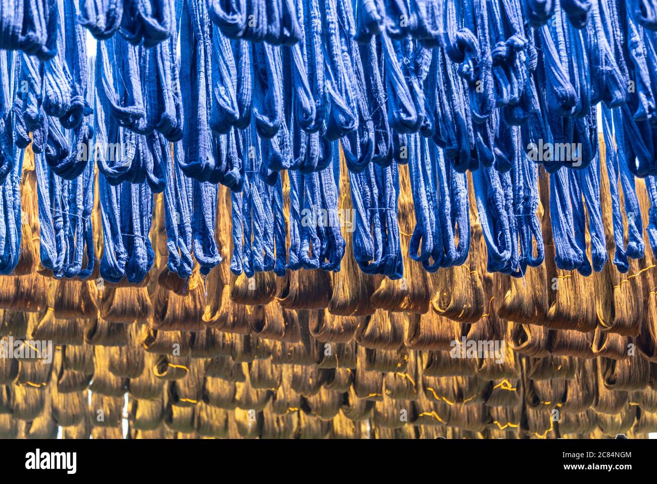 Blue dyed silk hanging in fabric weaving factory in Amarapura, Myanmar ...