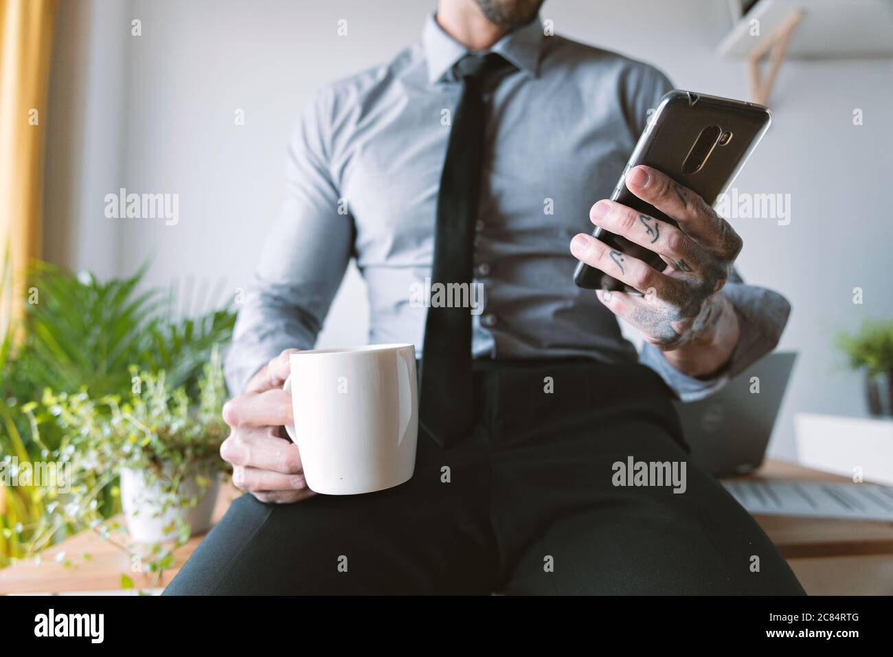 Young man checks mobile at work Stock Photo - Alamy