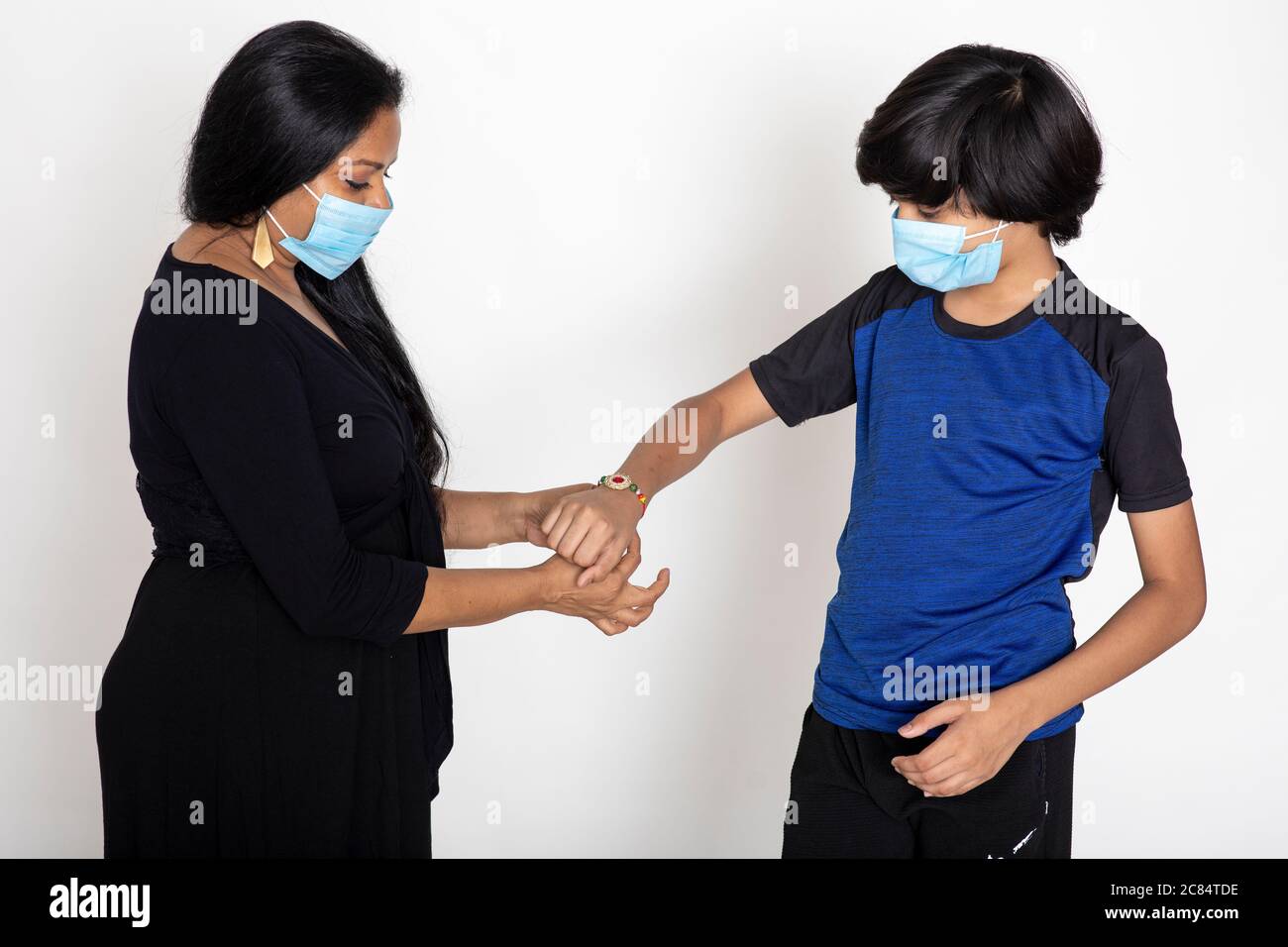 Indian woman ties Rakhi on her brother's hand on the occasion of Raksha ...
