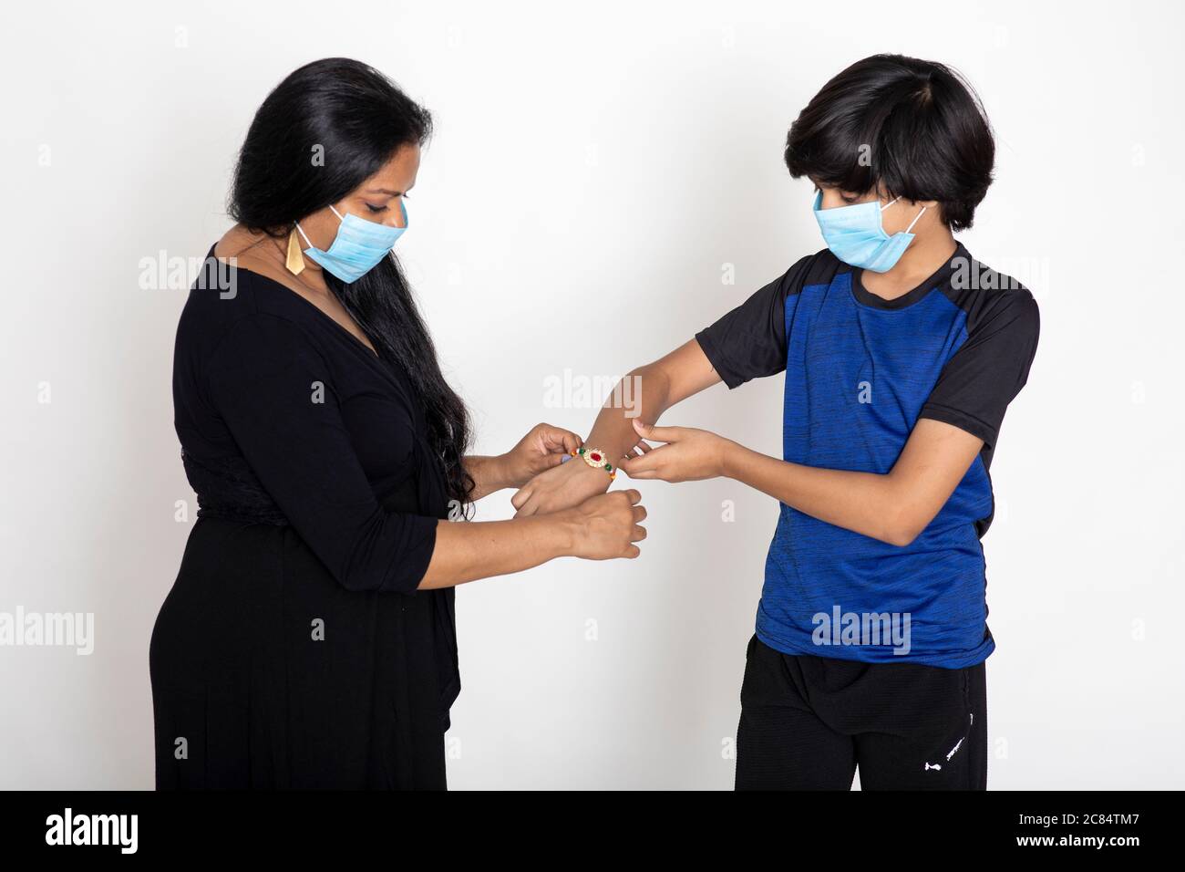 Indian woman ties Rakhi on her brother's hand on the occasion of Raksha ...