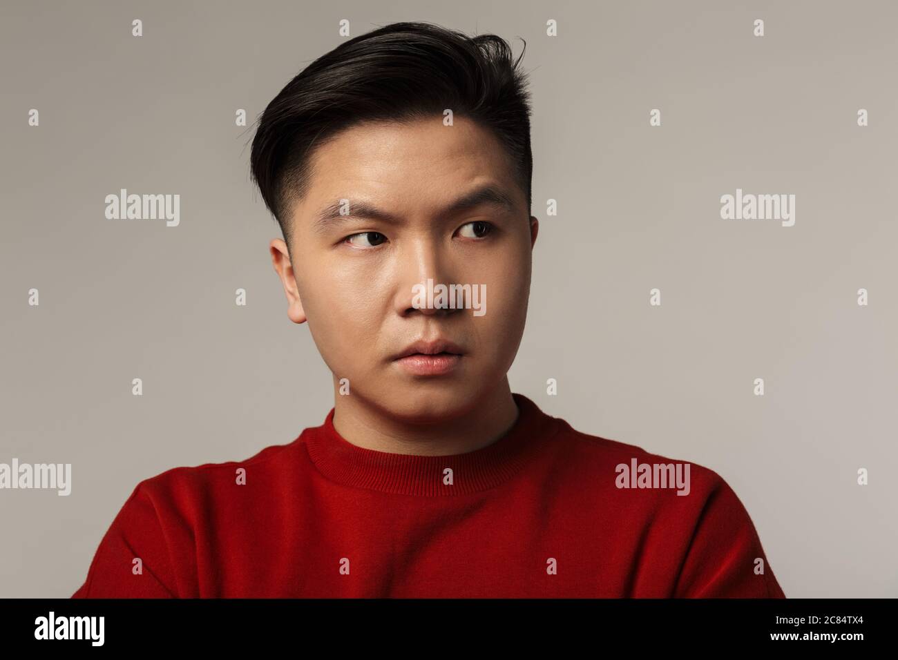 Image of displeased young asian man posing and looking aside isolated ...