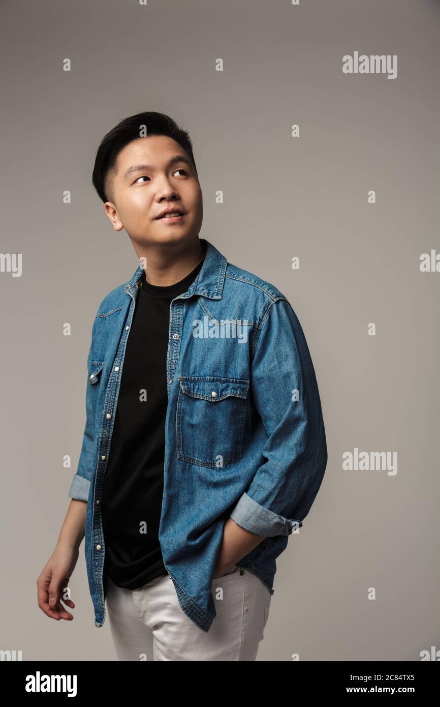 Image of young handsome asian man posing and looking upward isolated ...