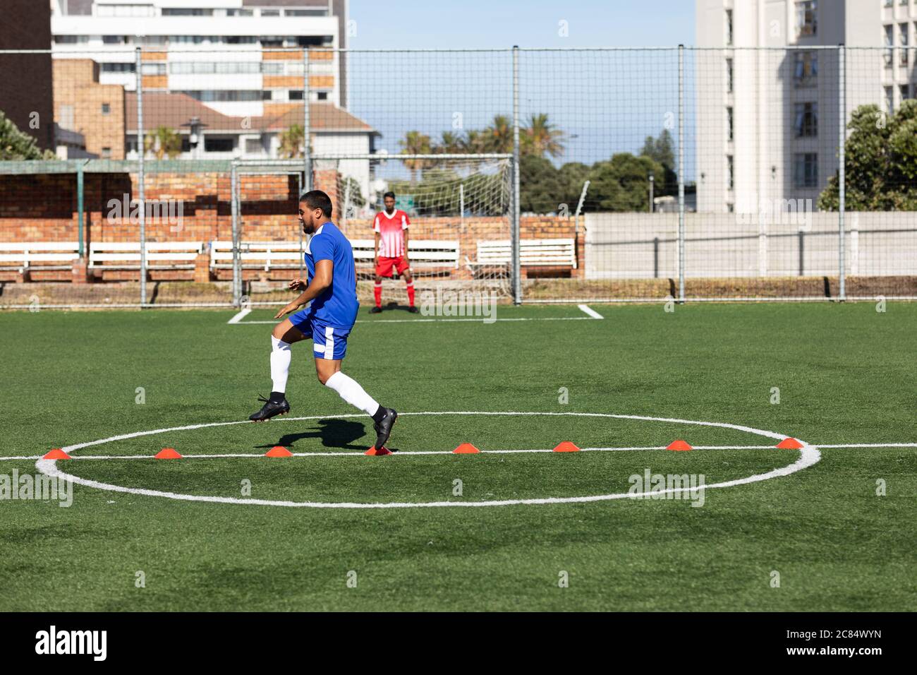 Mixed race male football player wearing a team strip training at a ...