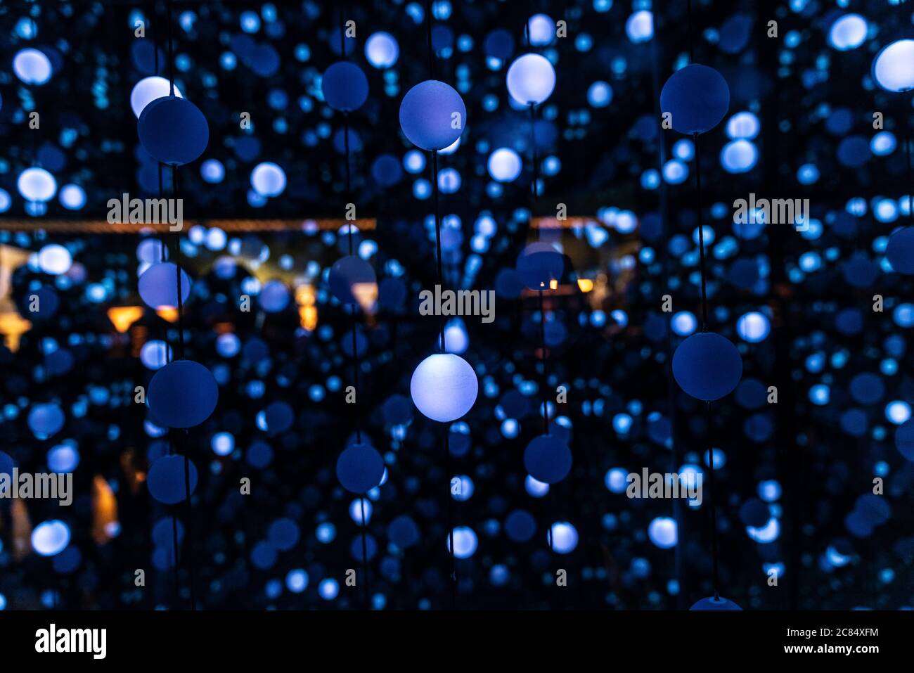 Many illuminated balls hung and linked by threads creating an infinite ...