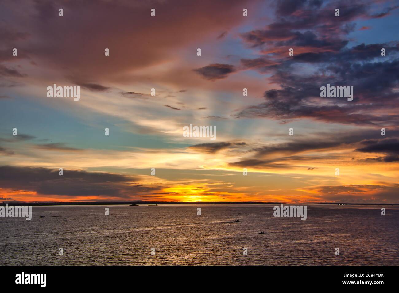 Dramatic sunset over the River Amazon with clouds of various hues over ...