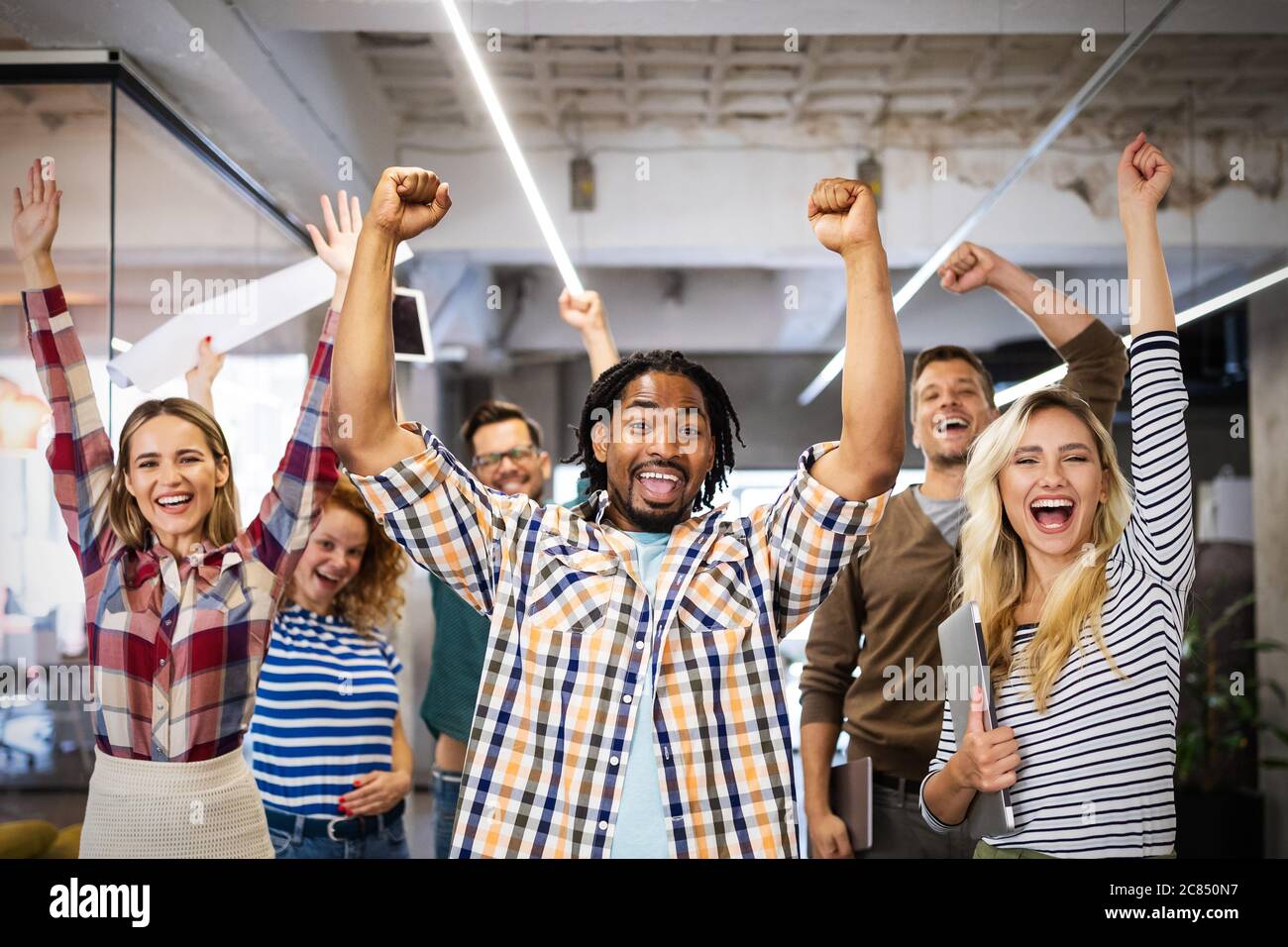 Group of successful happy business people in office celebrating profits ...