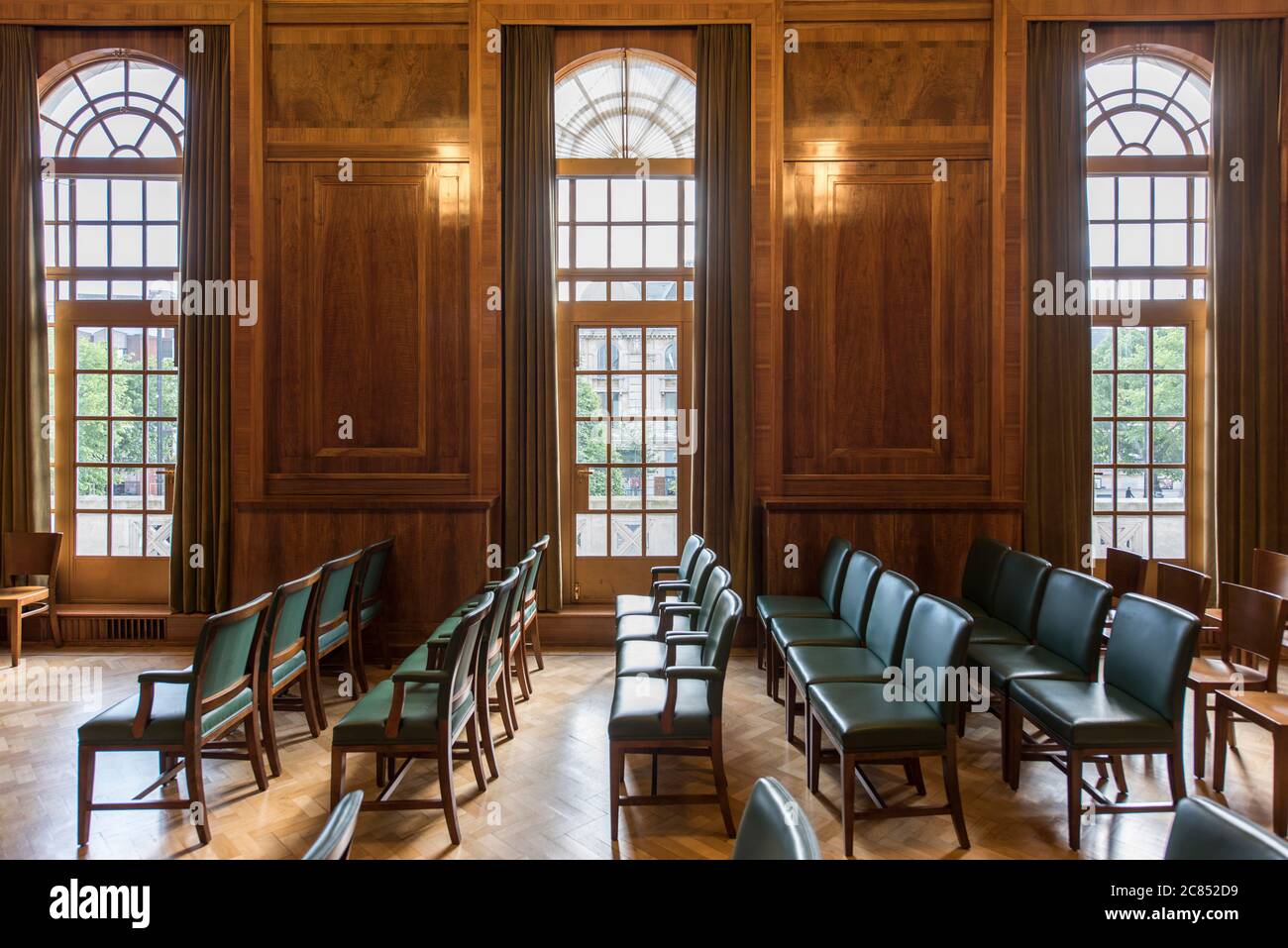 Committee room with timber panelling looking out to three arched ...