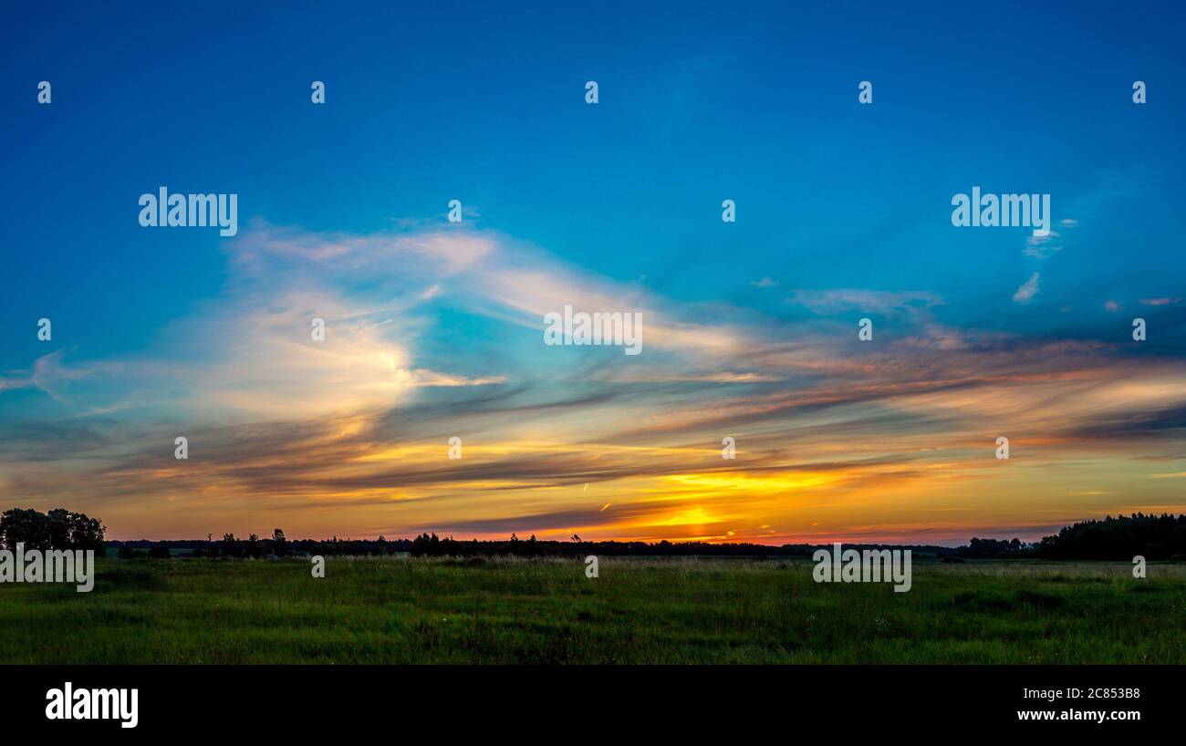 Beautiful sunrise over green field in a summer morning Stock Photo - Alamy