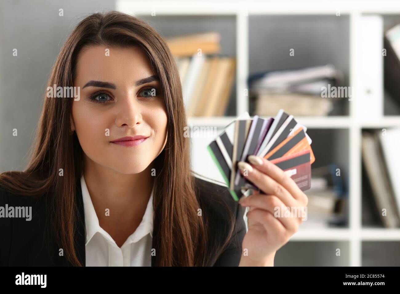 Smiling female manager holding bunch of bank cards Stock Photo - Alamy