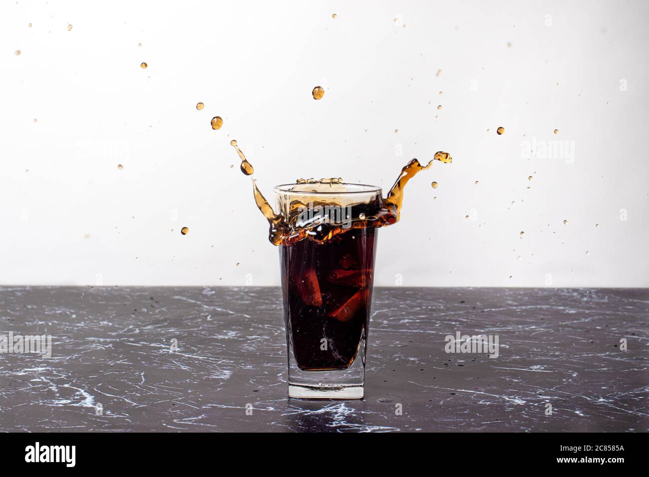 Splashing the drink. Sweet liquid spills out of a glass Stock Photo - Alamy