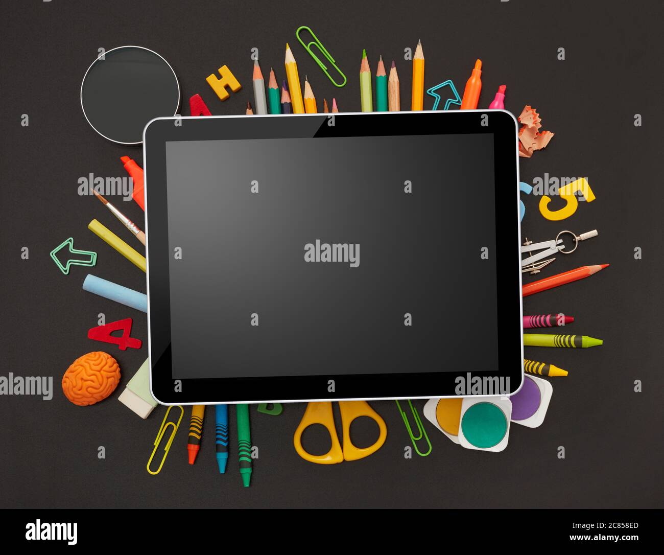Digital tablet and school supplies on blackboard Stock Photo - Alamy
